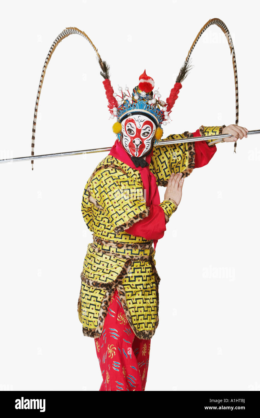 Side profile of a male Chinese opera performer gesturing with a weapon ...