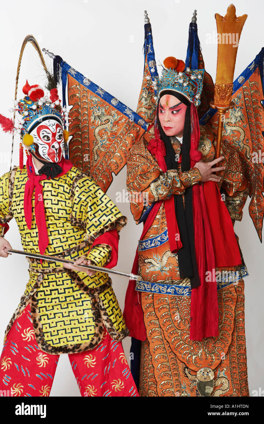 Two male Chinese opera performers gesturing with weapons Stock Photo ...