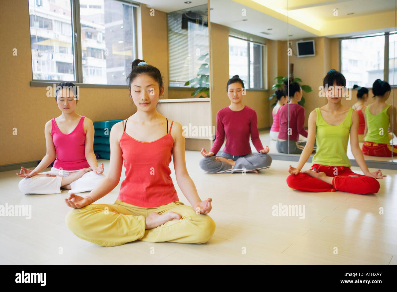 Four young women sitting in the lotus position Stock Photo - Alamy