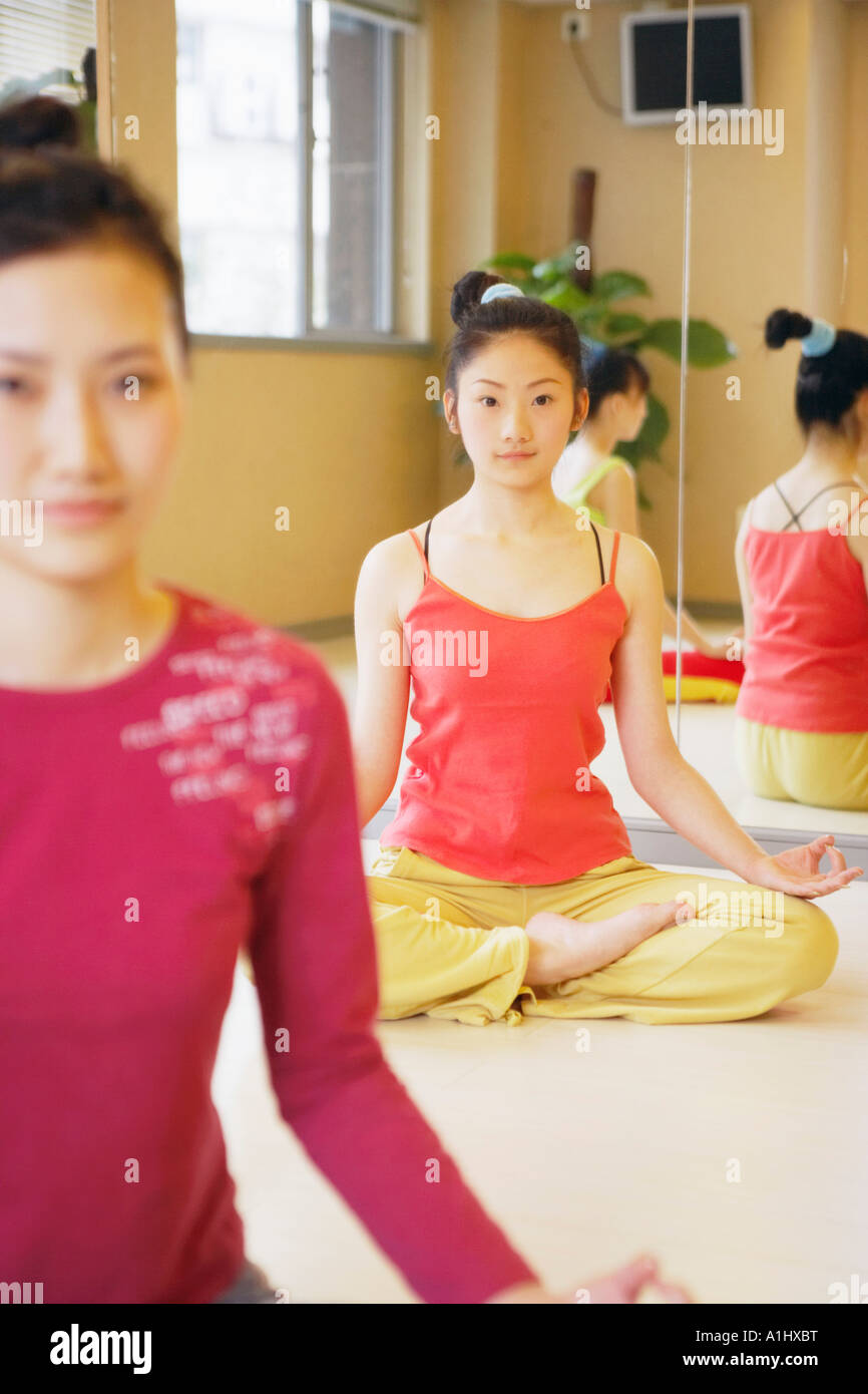 Three young women sitting in the lotus position Stock Photo - Alamy