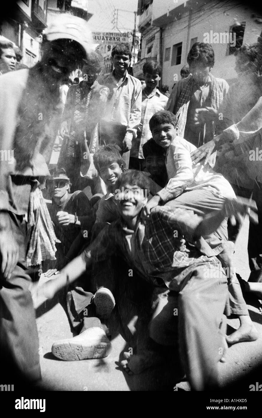crowd of young men throwing colored powder during the color festival ...