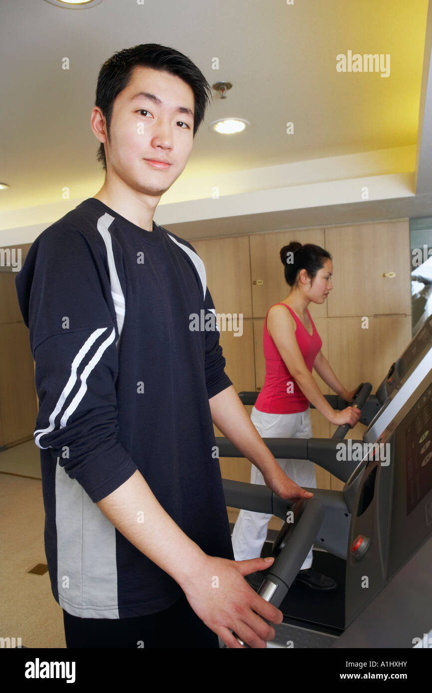 Side profile of a young man and a young woman exercising in a gym Stock ...