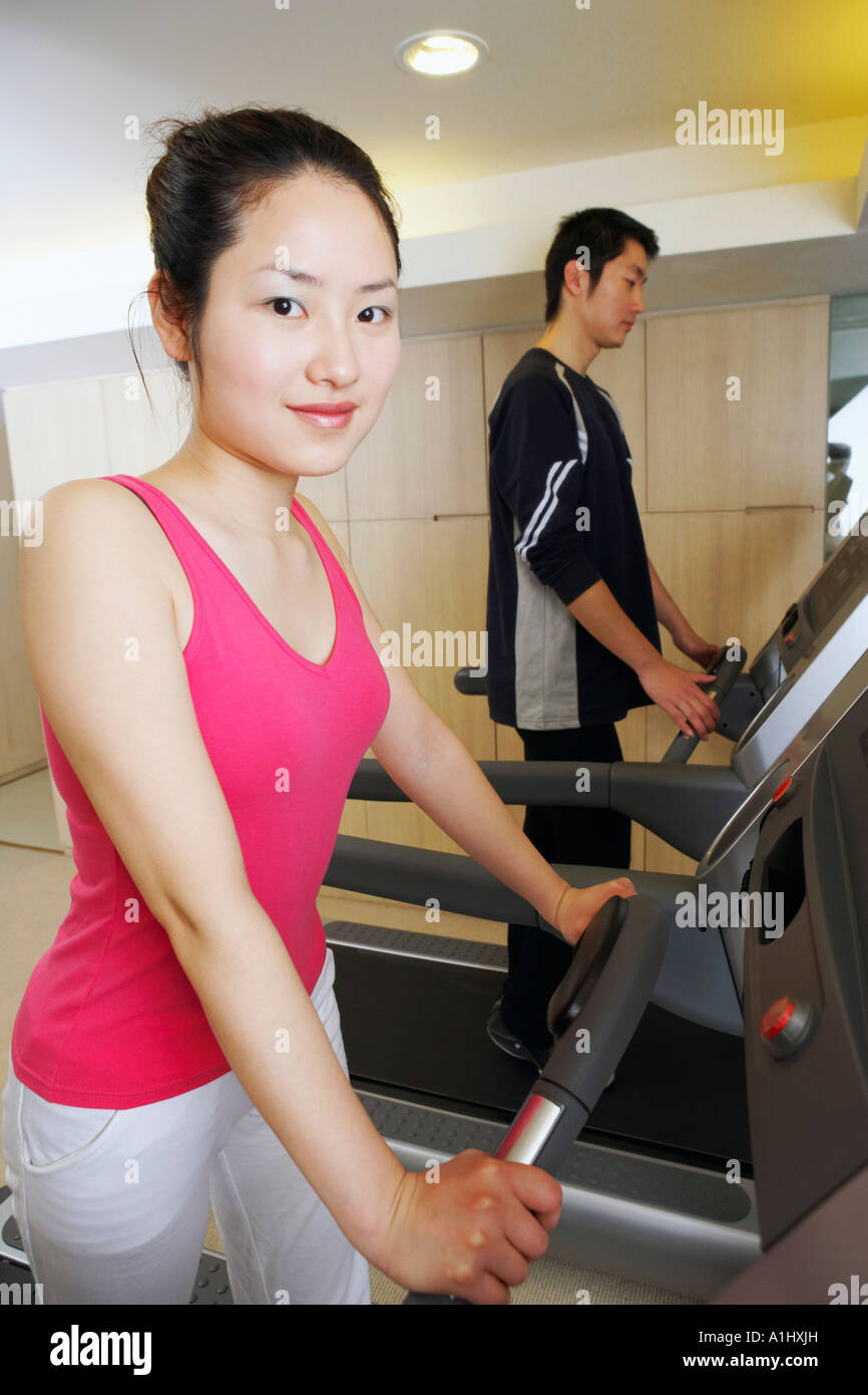 Side profile of a young woman and a young man exercising in a gym Stock ...