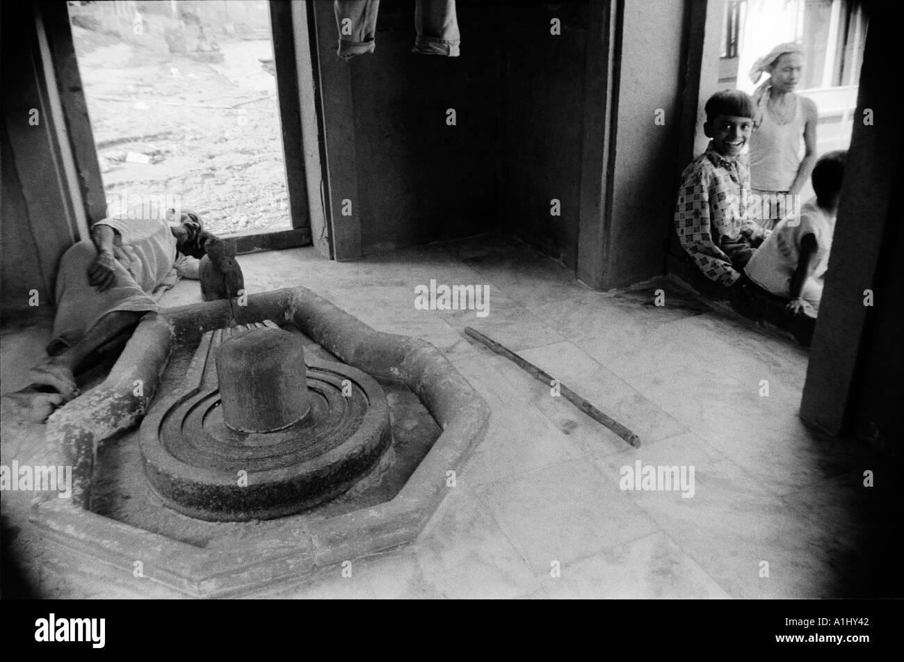 Old man sleeping by the Shiva Lingam in a little Shiva Temple on the ...