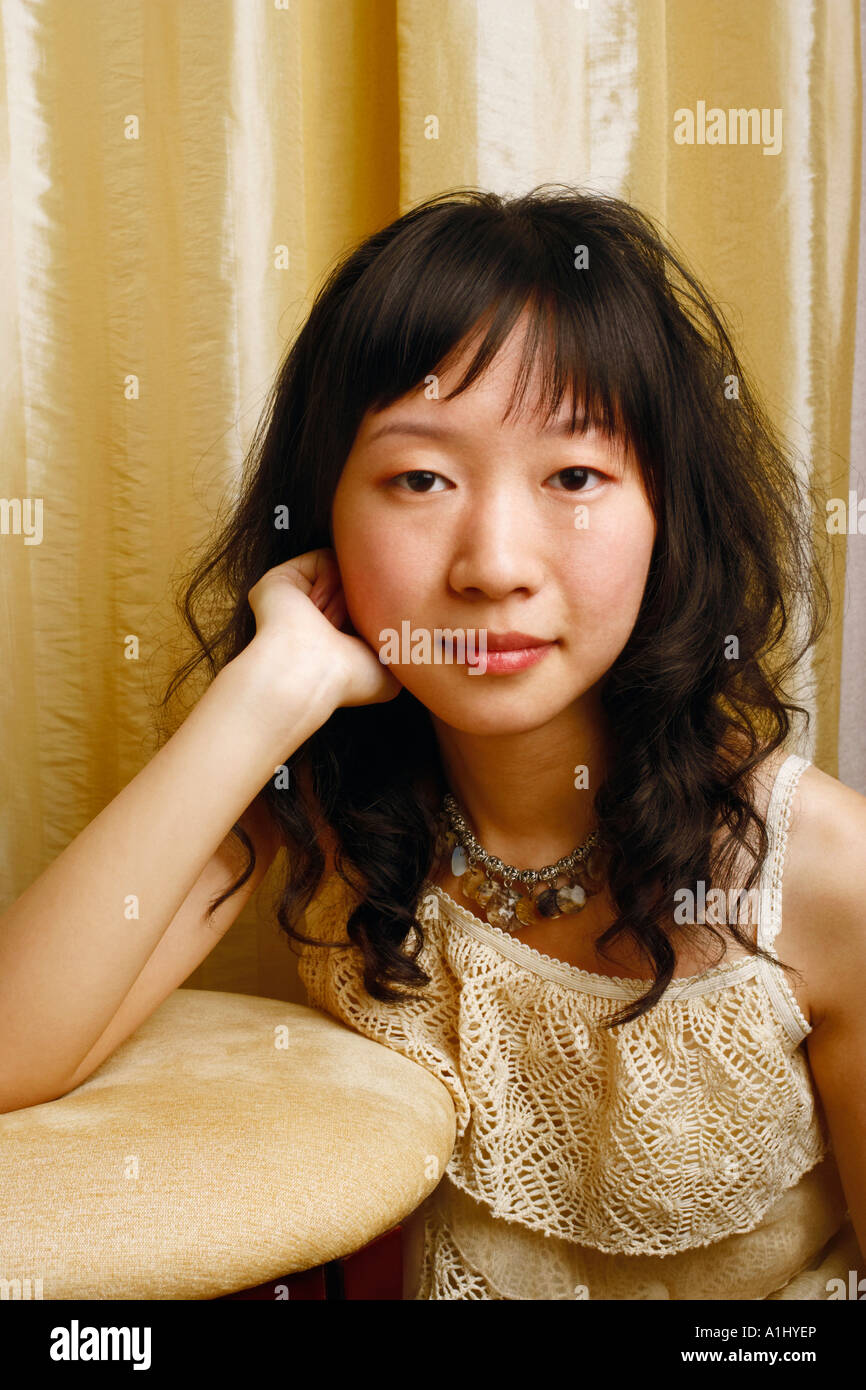 Portrait of a young woman leaning over a stool Stock Photo - Alamy