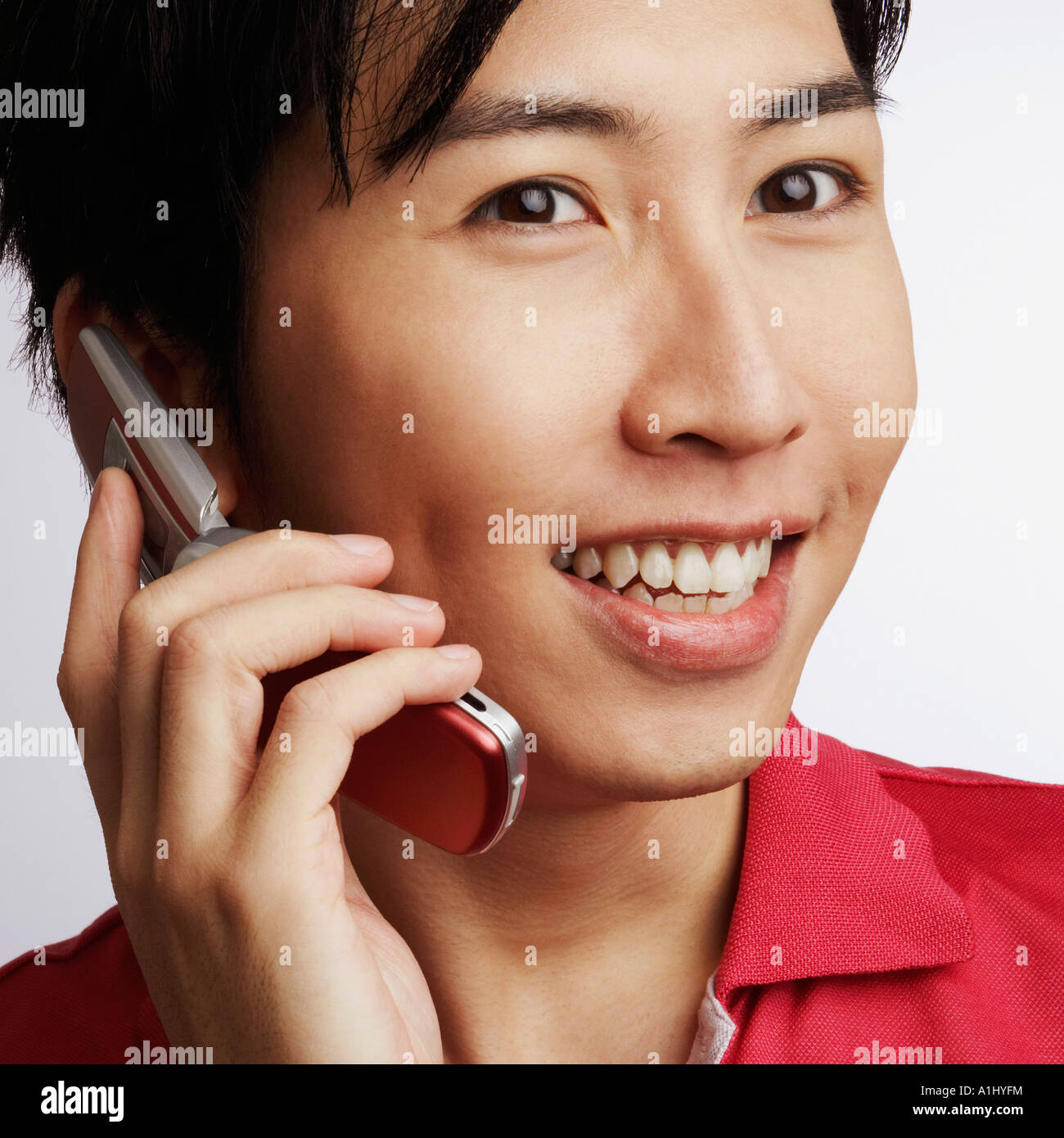 Close-up of a young man talking on a flip phone Stock Photo - Alamy