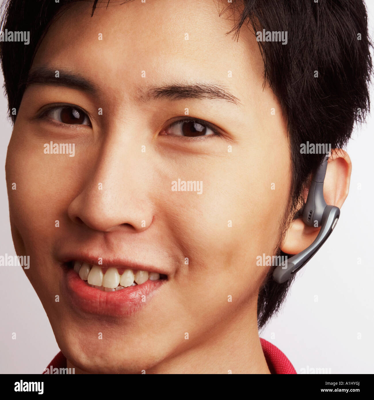 Portrait of a young man wearing a hands-free device Stock Photo - Alamy