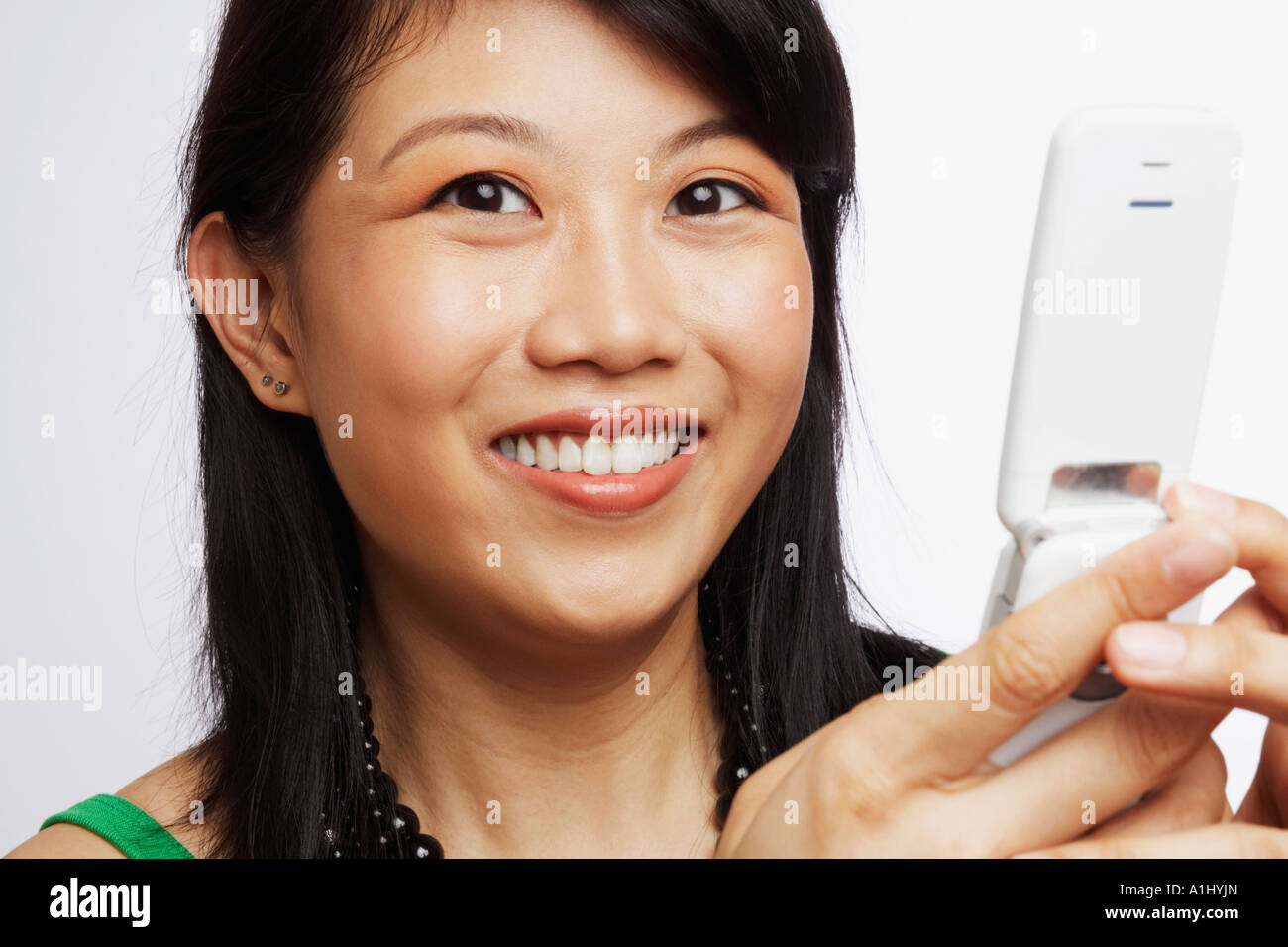 Portrait of a young woman smiling and operating a mobile phone Stock ...