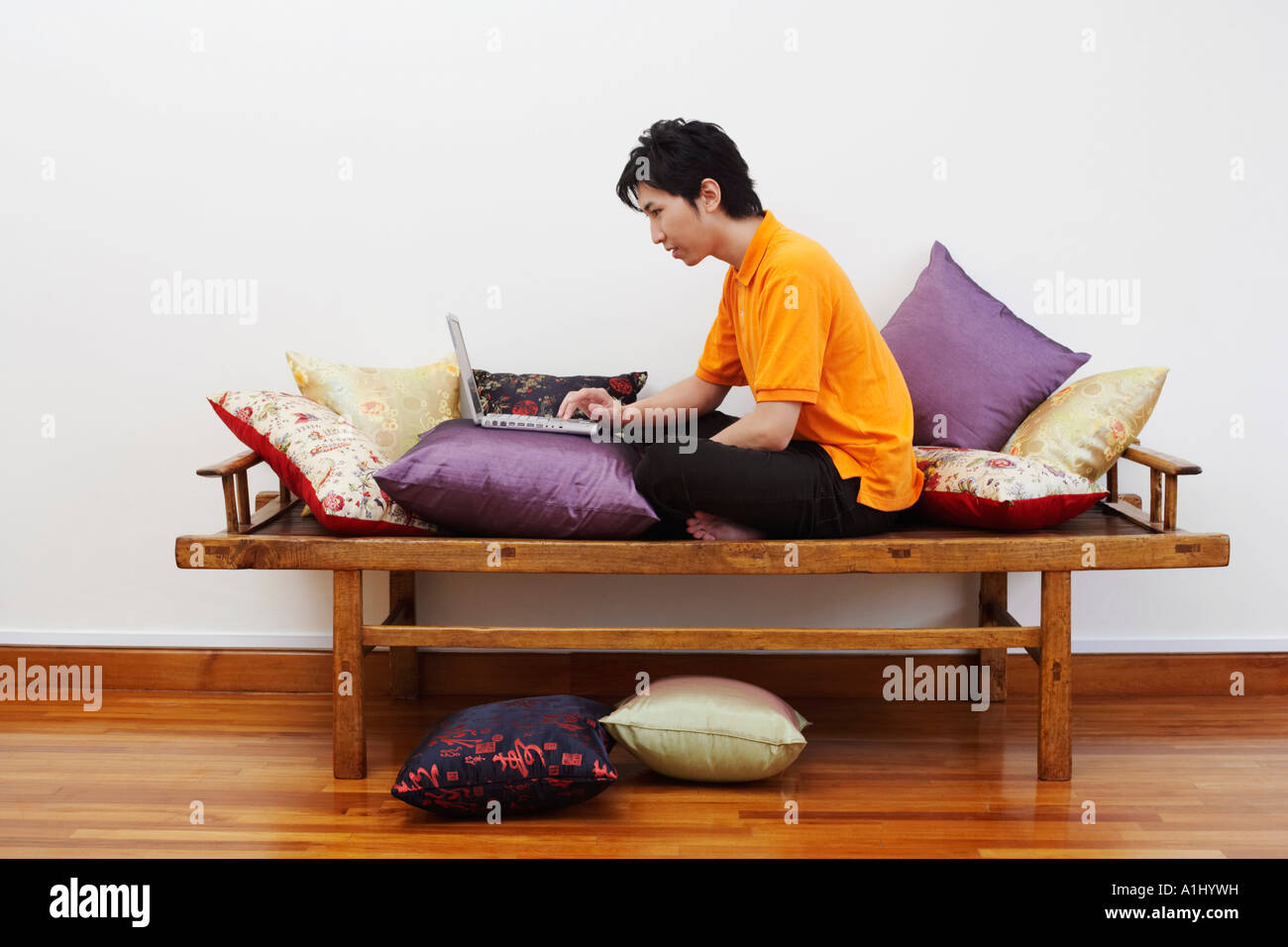 Side profile of a young man sitting on a bench and using a laptop Stock ...