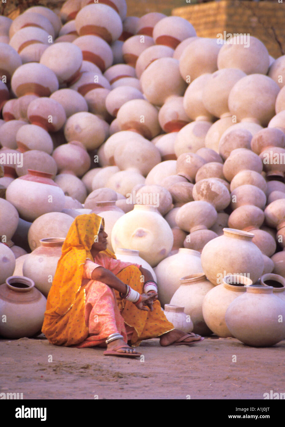 Woman is sitting down waiting patiently for clients, in a street of ...