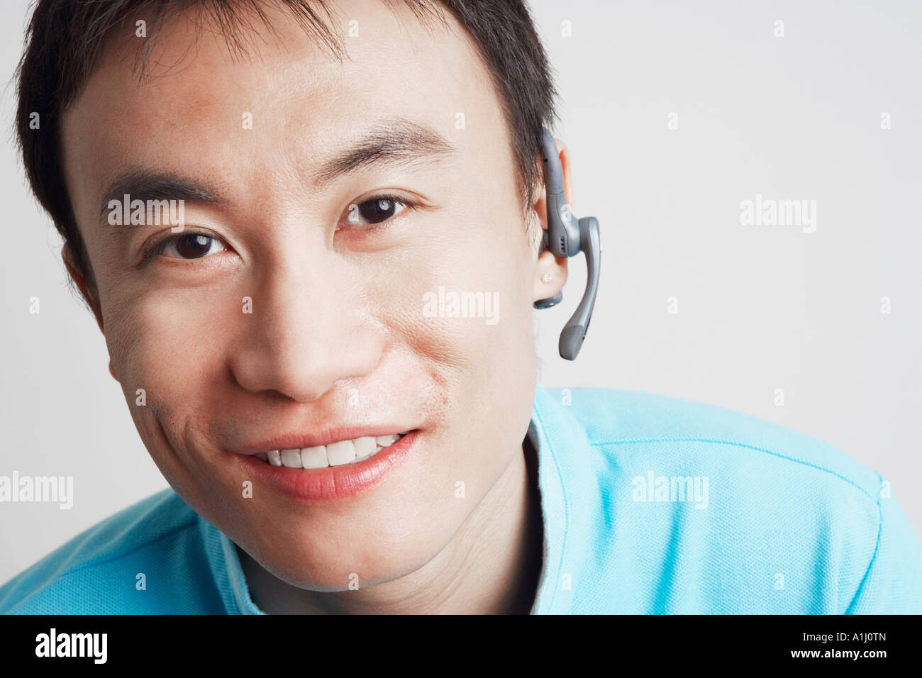 Portrait of a young man wearing a hands-free device and smiling Stock ...