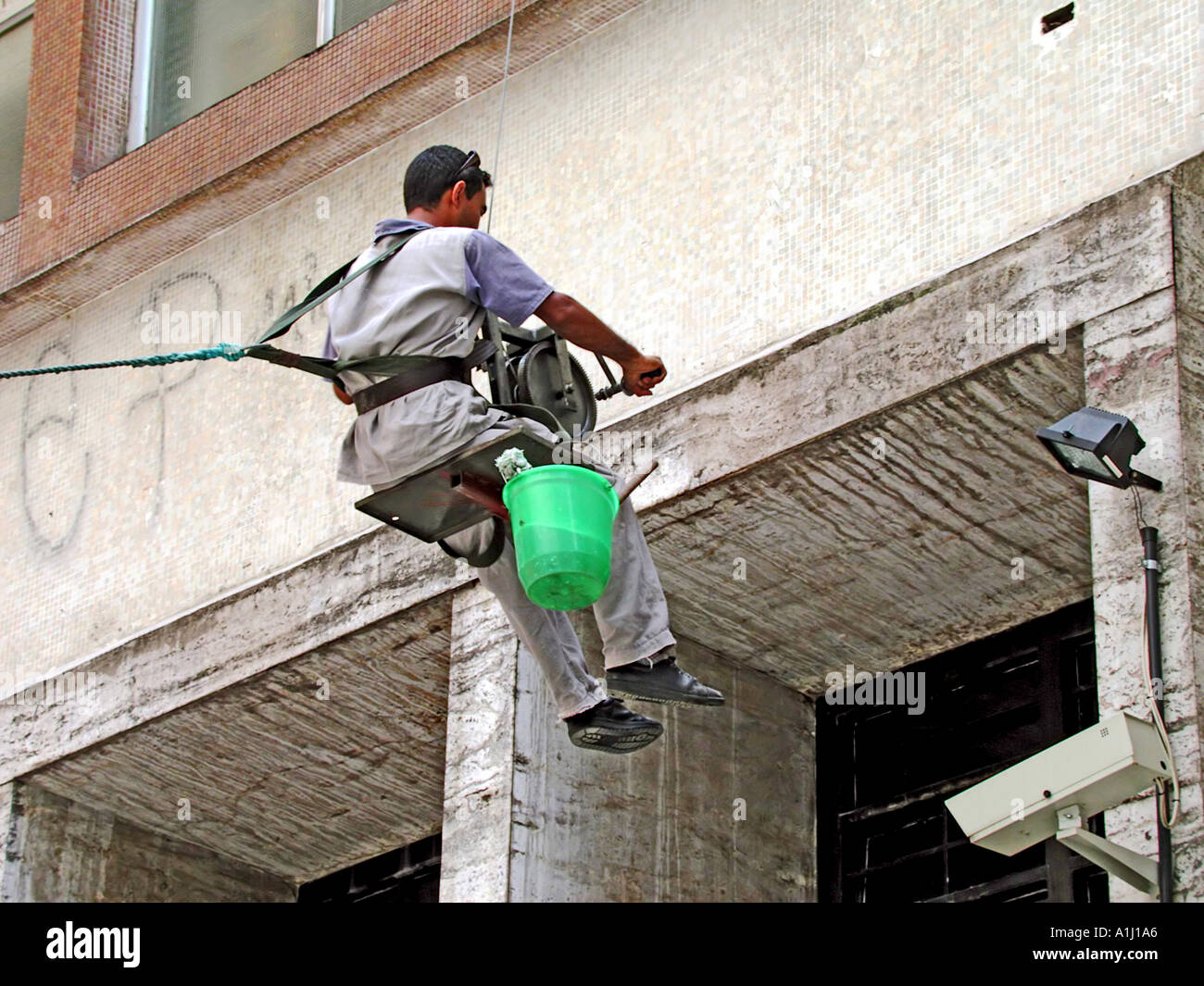 Hung man cleaning building facade Stock Photo - Alamy