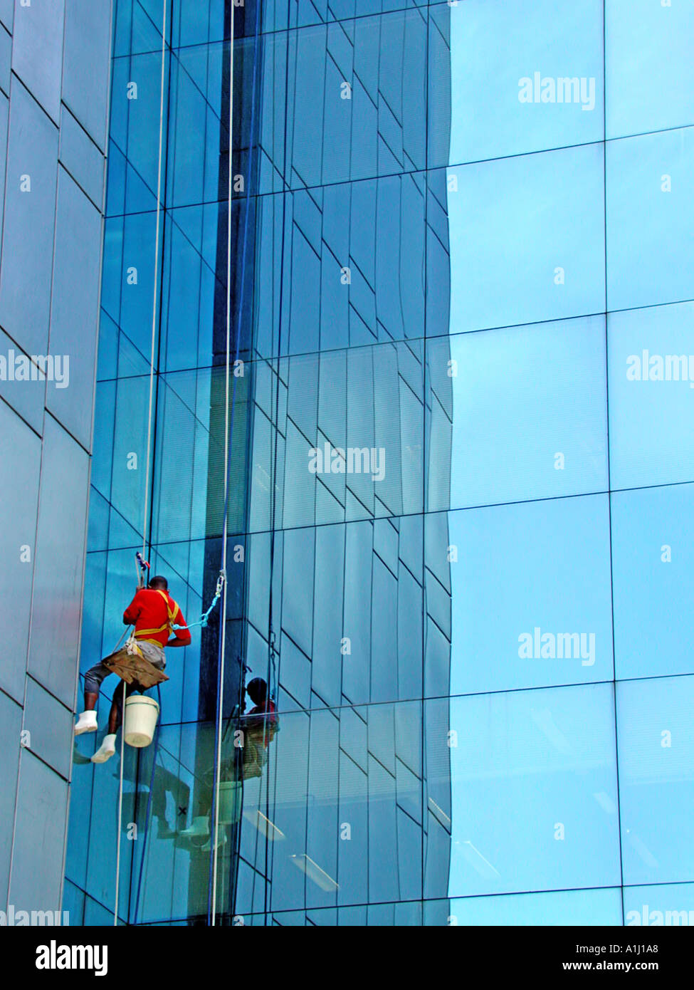 Hung man cleaning building facade Stock Photo - Alamy
