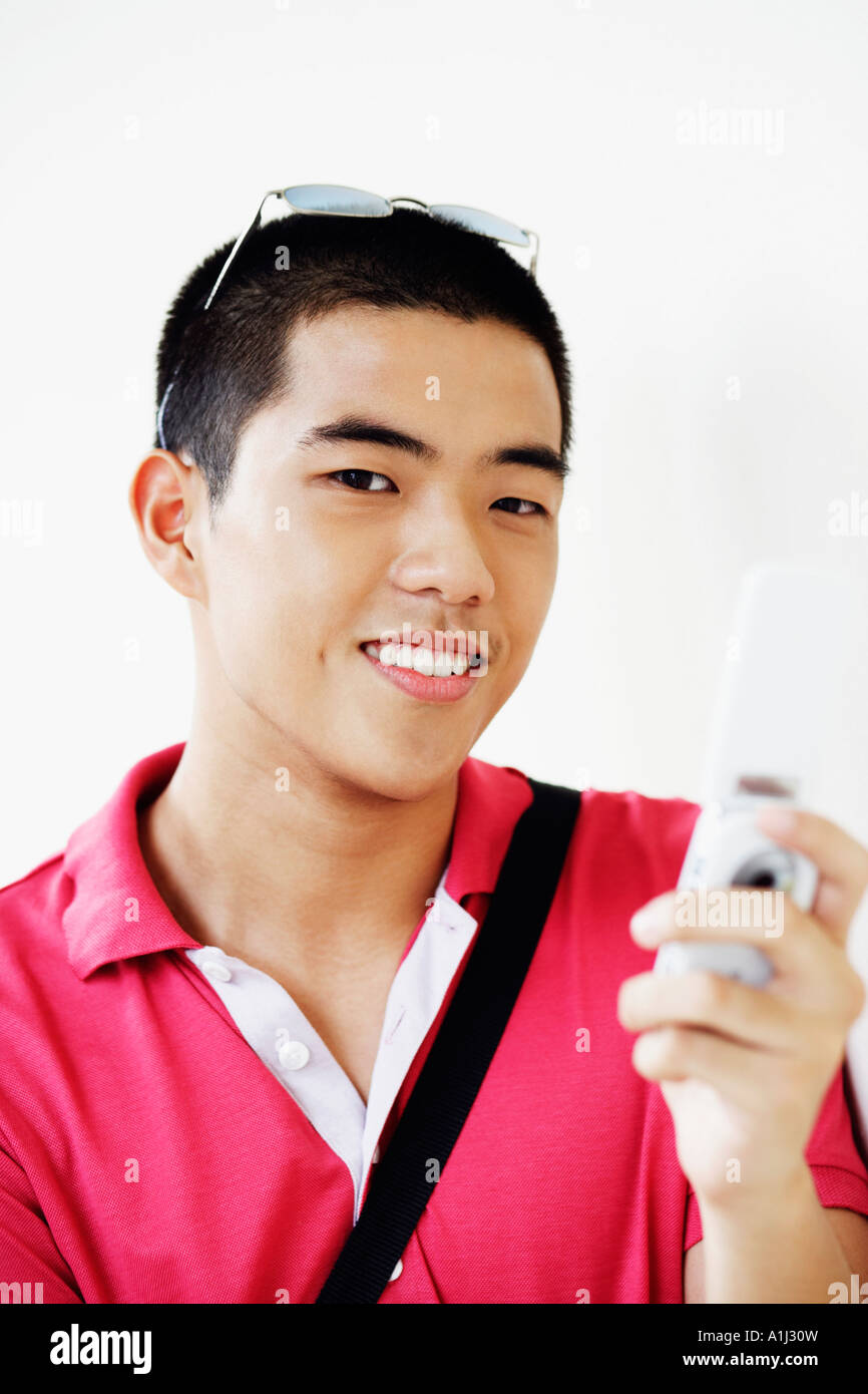 Portrait of a young man operating a mobile phone Stock Photo - Alamy