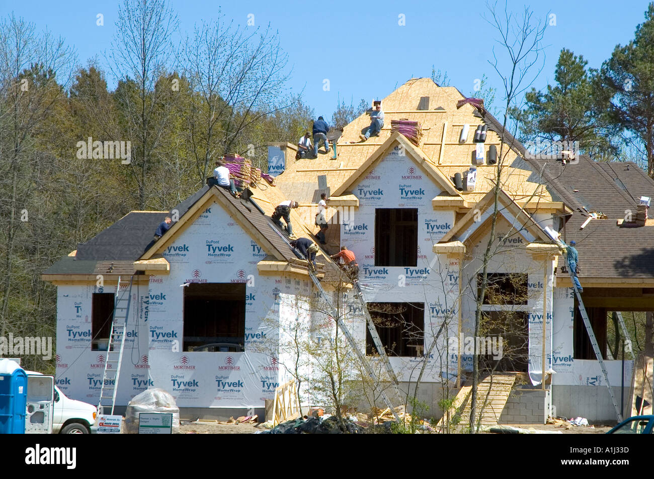 Construction roofing crew completes work by installing roof on a new ...