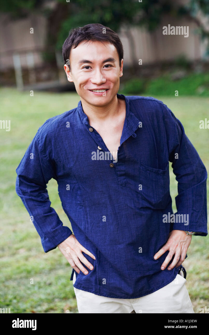 Portrait of a mid adult man smiling with arms akimbo Stock Photo - Alamy