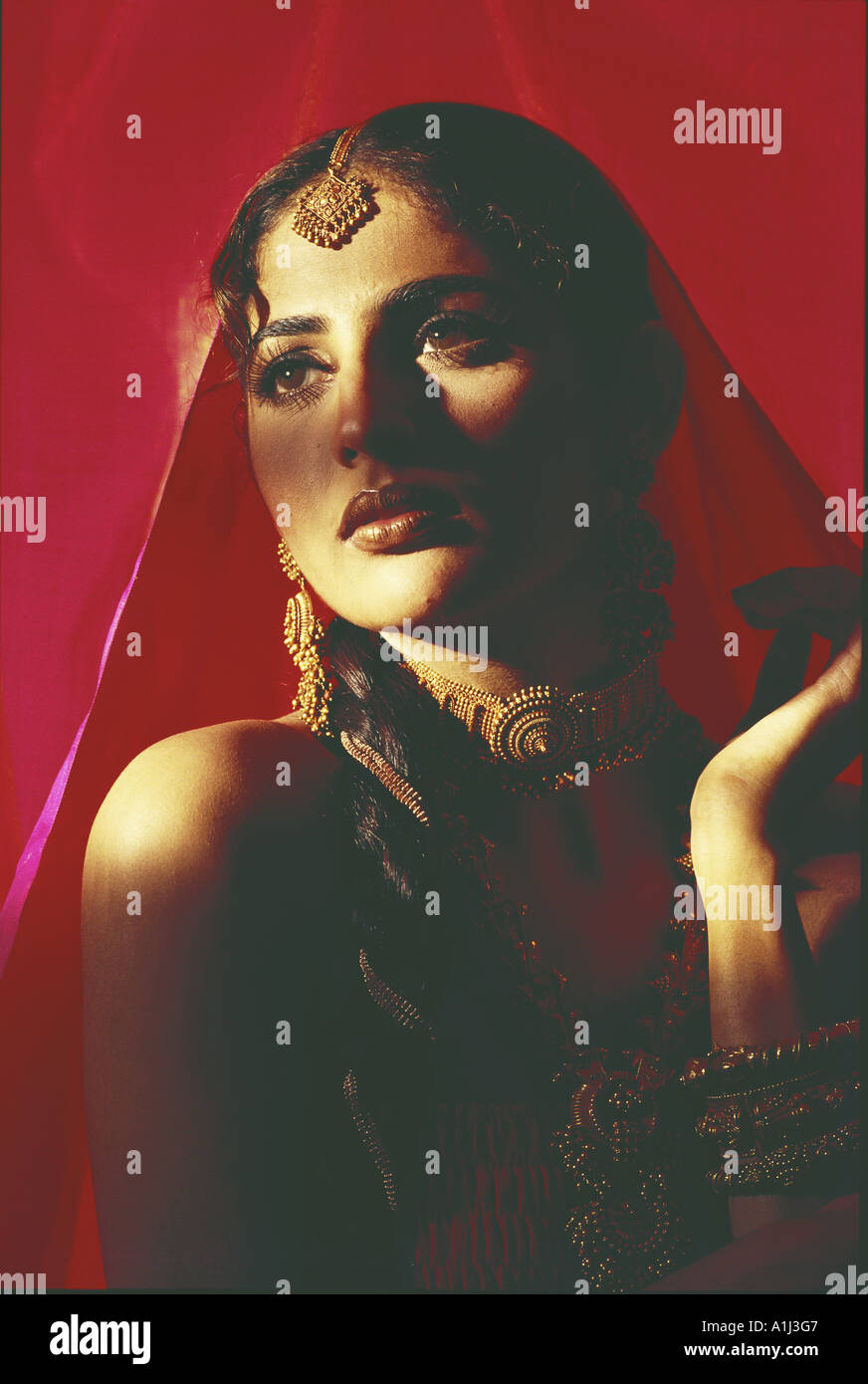 Indian woman with gold jewelry on red background India MR#324 Stock ...