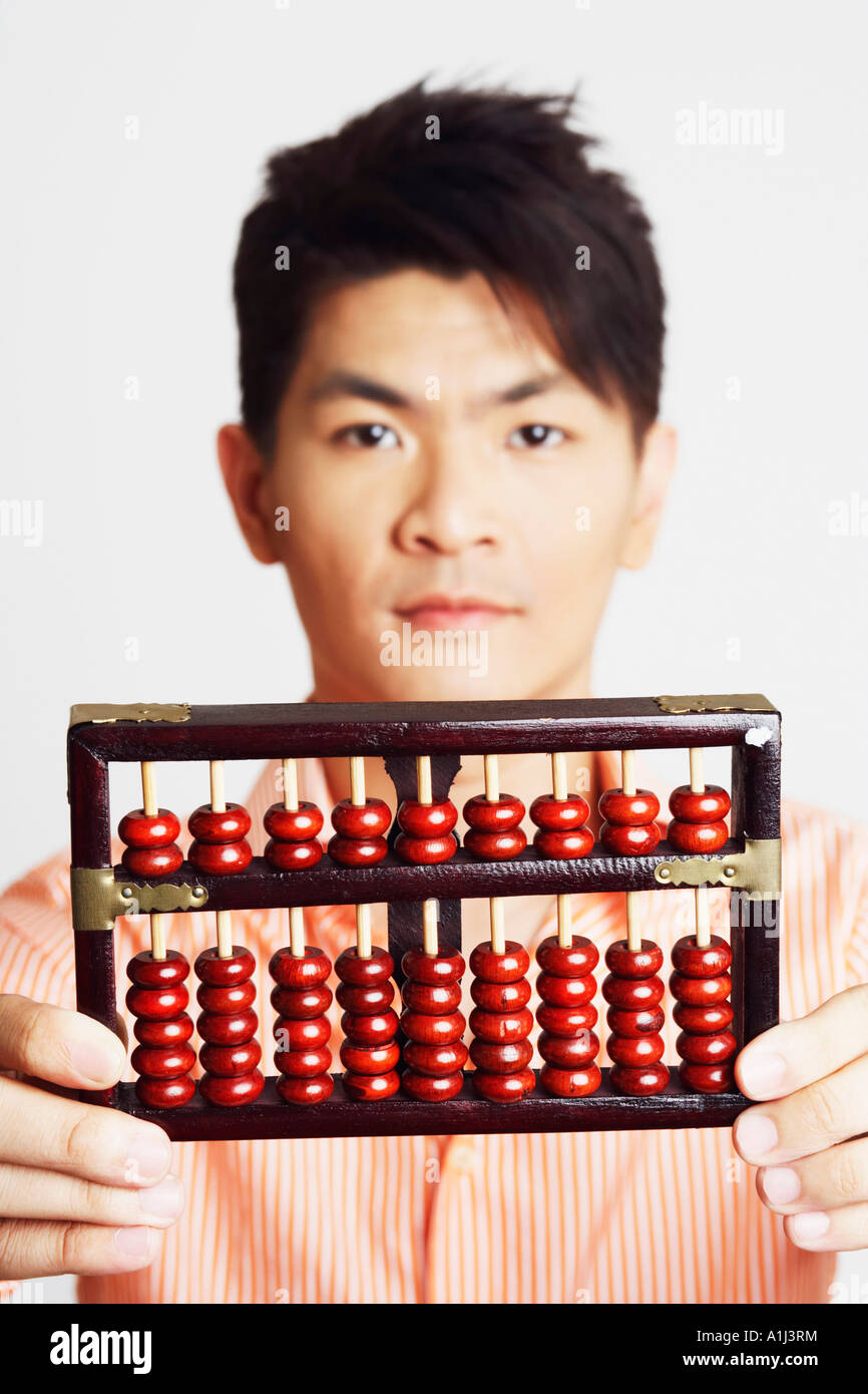 Portrait of a young man holding an abacus Stock Photo - Alamy