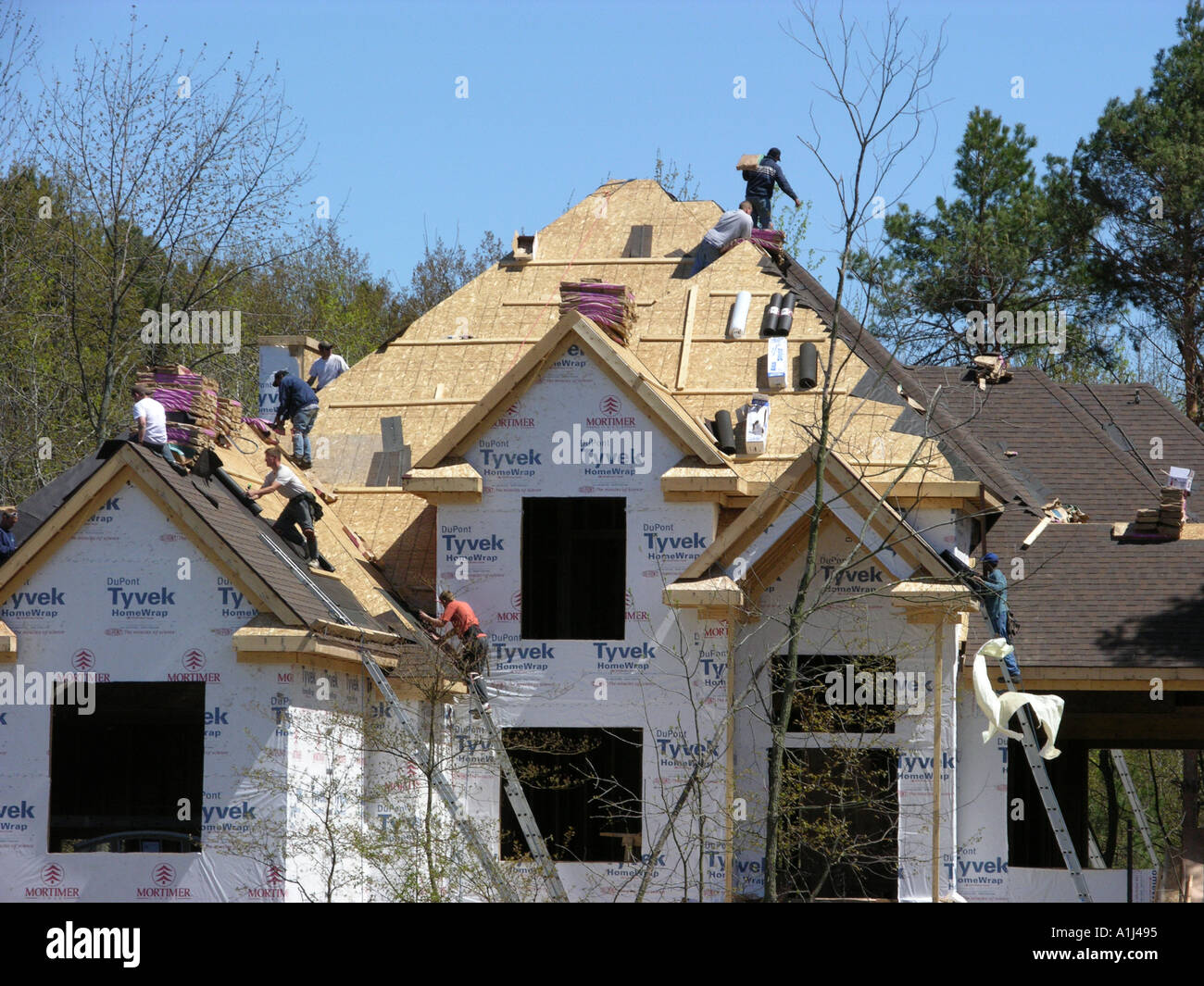 Construction roofing crew completes work by installing roof on a new ...