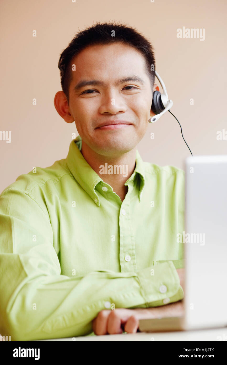 Portrait of a male customer service representative using a laptop and ...