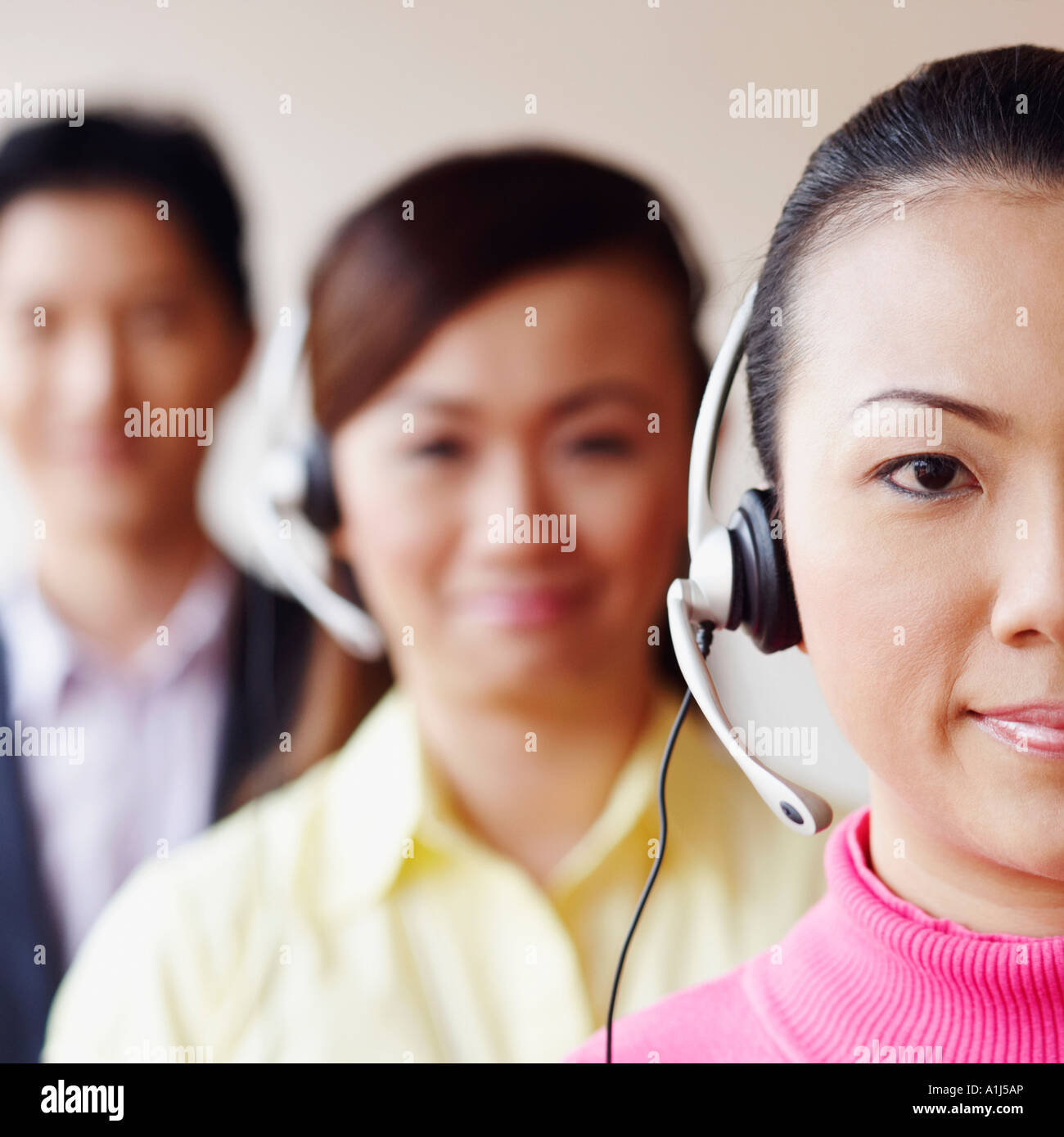 Portrait of a female customer service representative with two ...