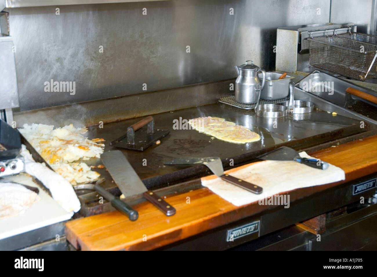 A grill with food being prepared on it in a short order restaurant ...