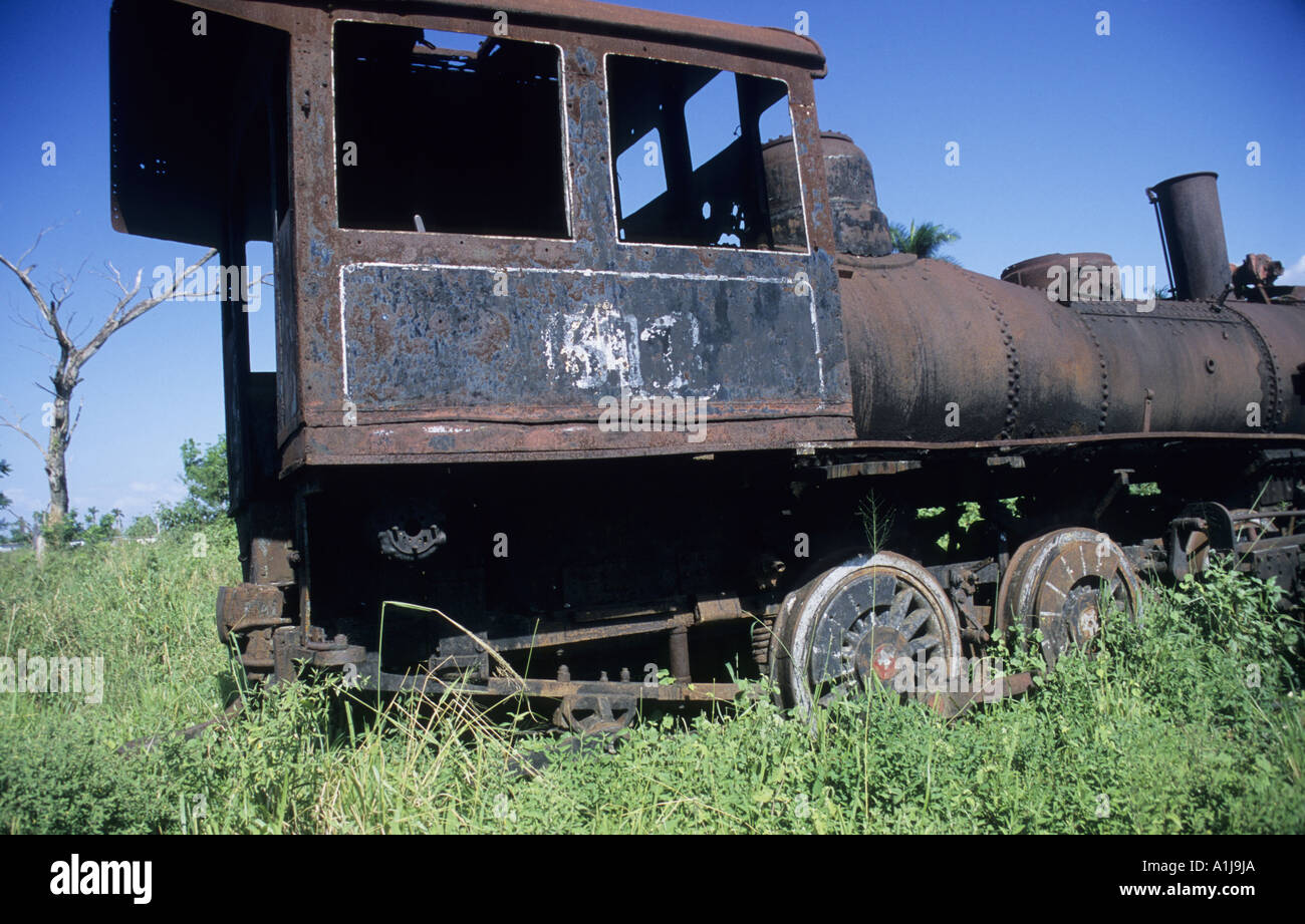 Old, rusted, locomotive resting near an old sugarfactory in a place ...