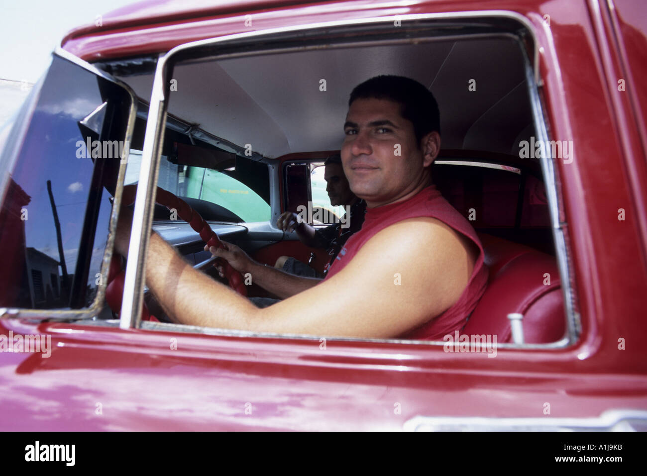 The proud owner in his beautifully kept up red American vintage car in ...