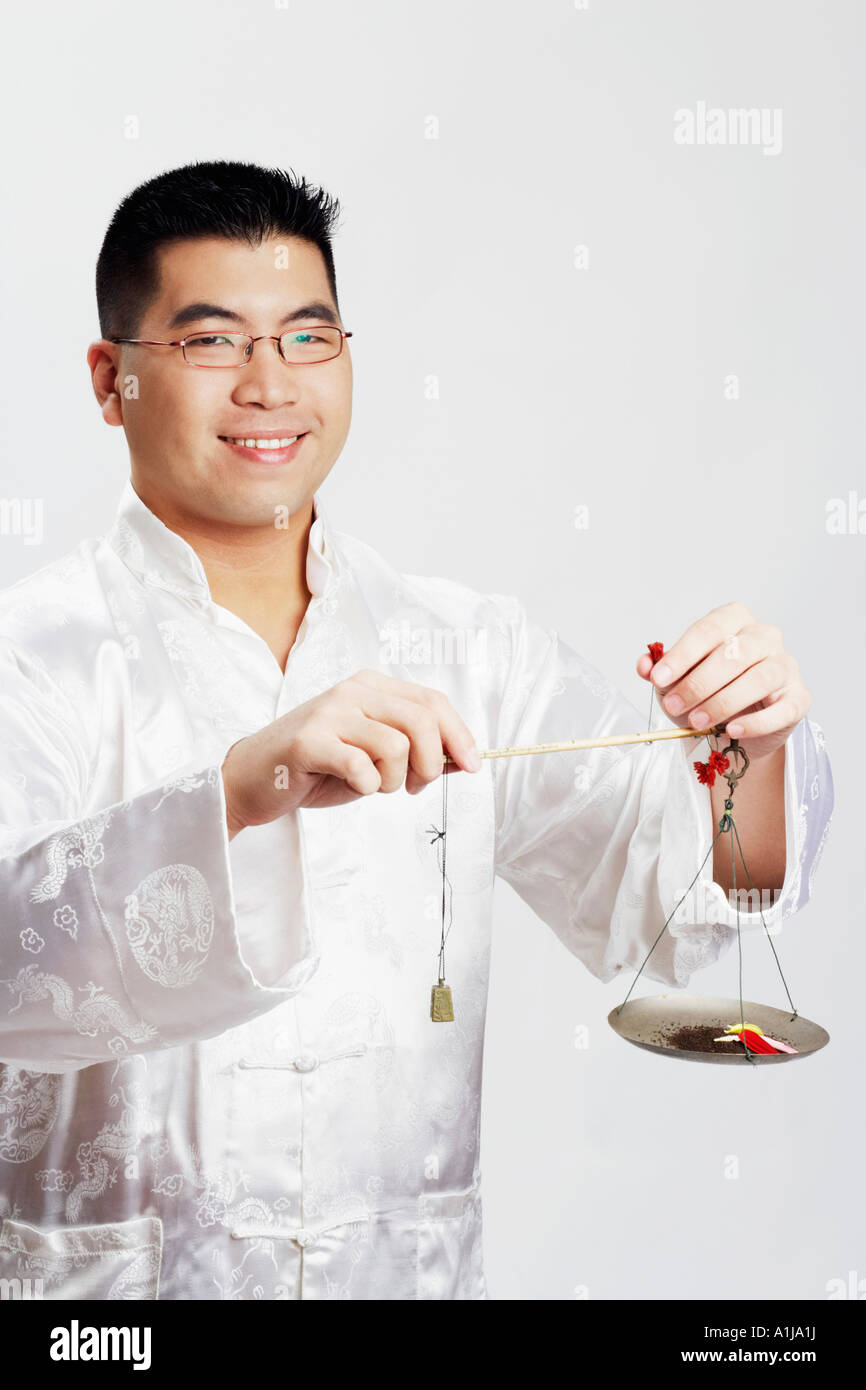 Portrait of a young man holding a balance scale Stock Photo - Alamy