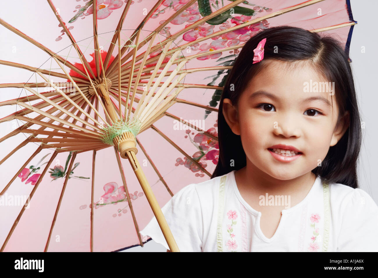 Portrait of a girl holding a parasol and smiling Stock Photo - Alamy