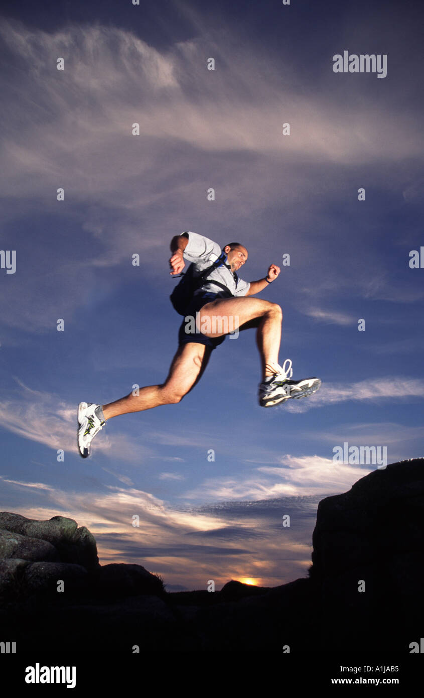 Man jumping and running with dramatic sky backdrop Stock Photo - Alamy