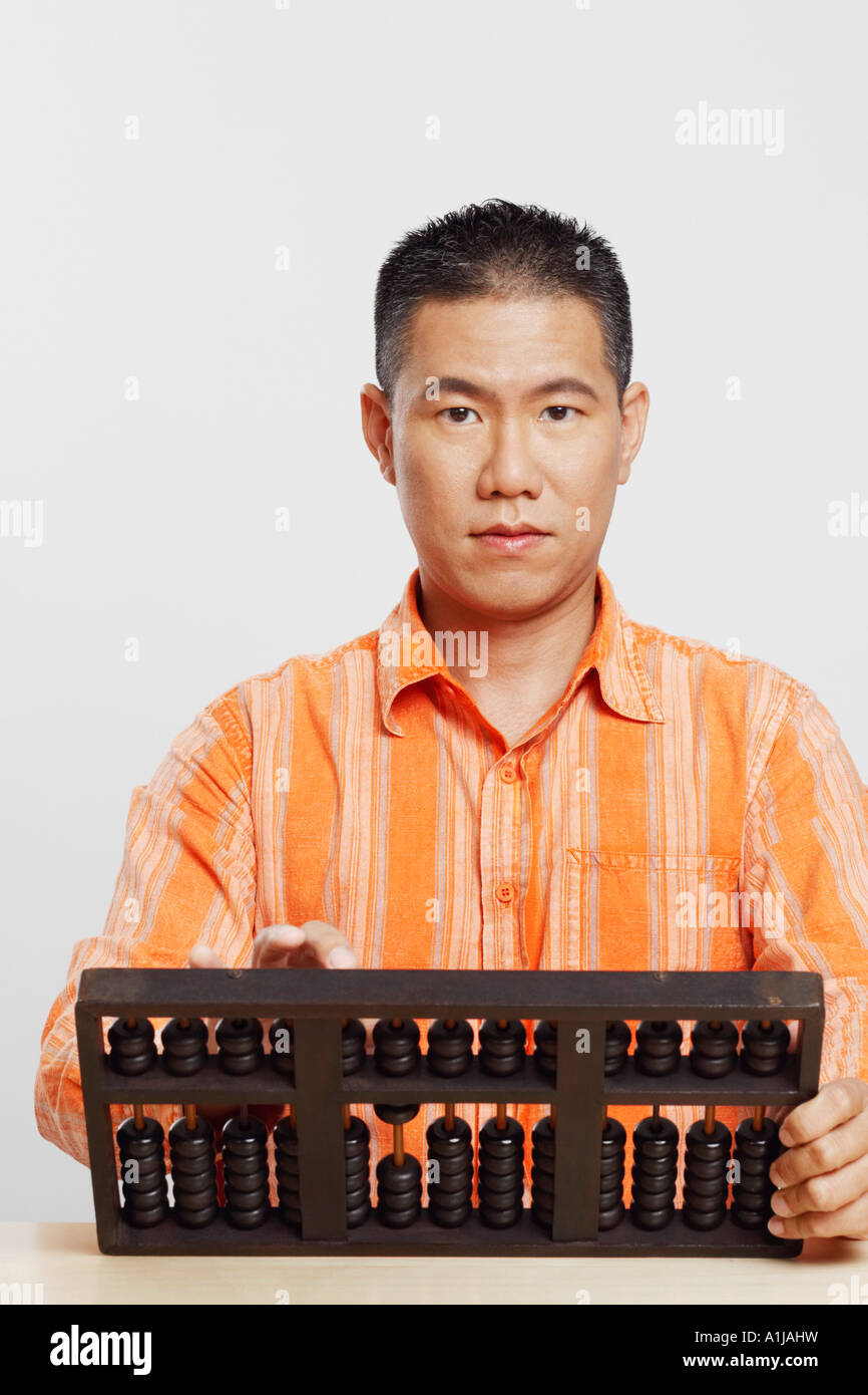 Portrait of a mid adult man using an abacus Stock Photo - Alamy