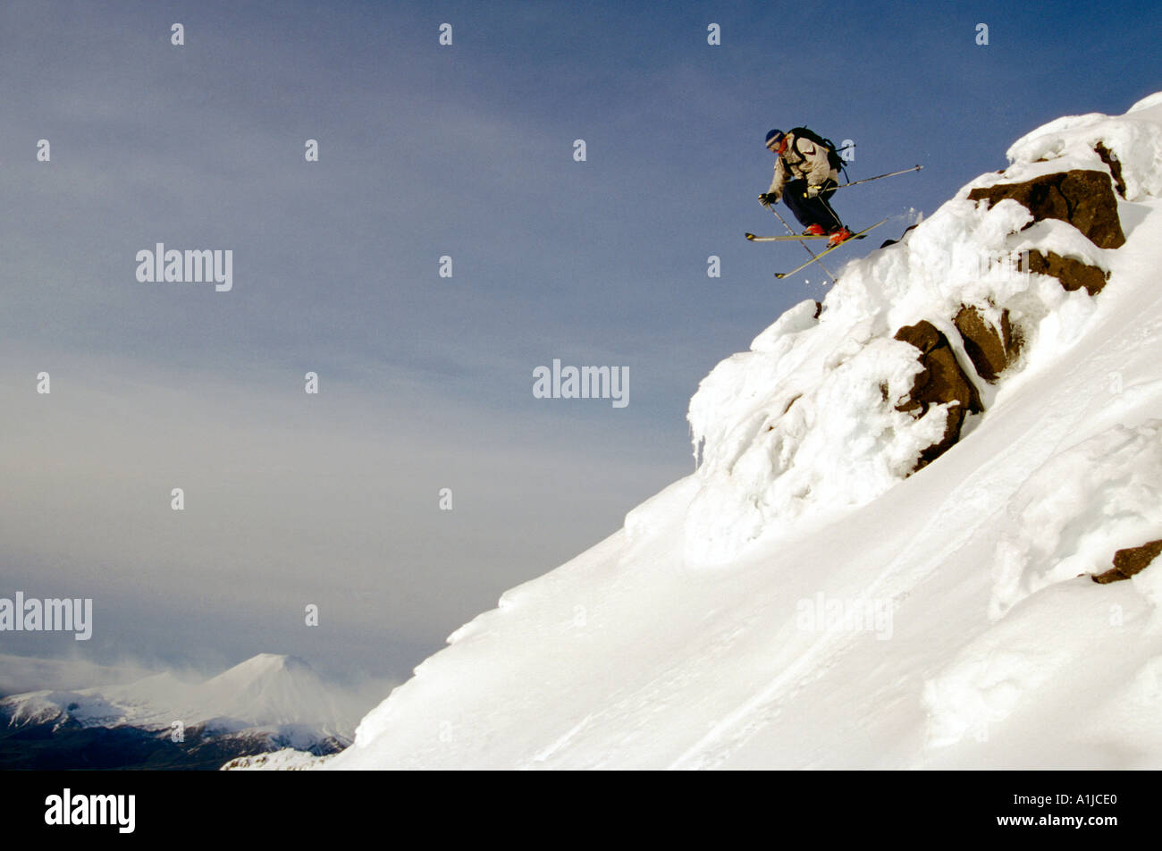Snow skier flying off cliff Stock Photo - Alamy
