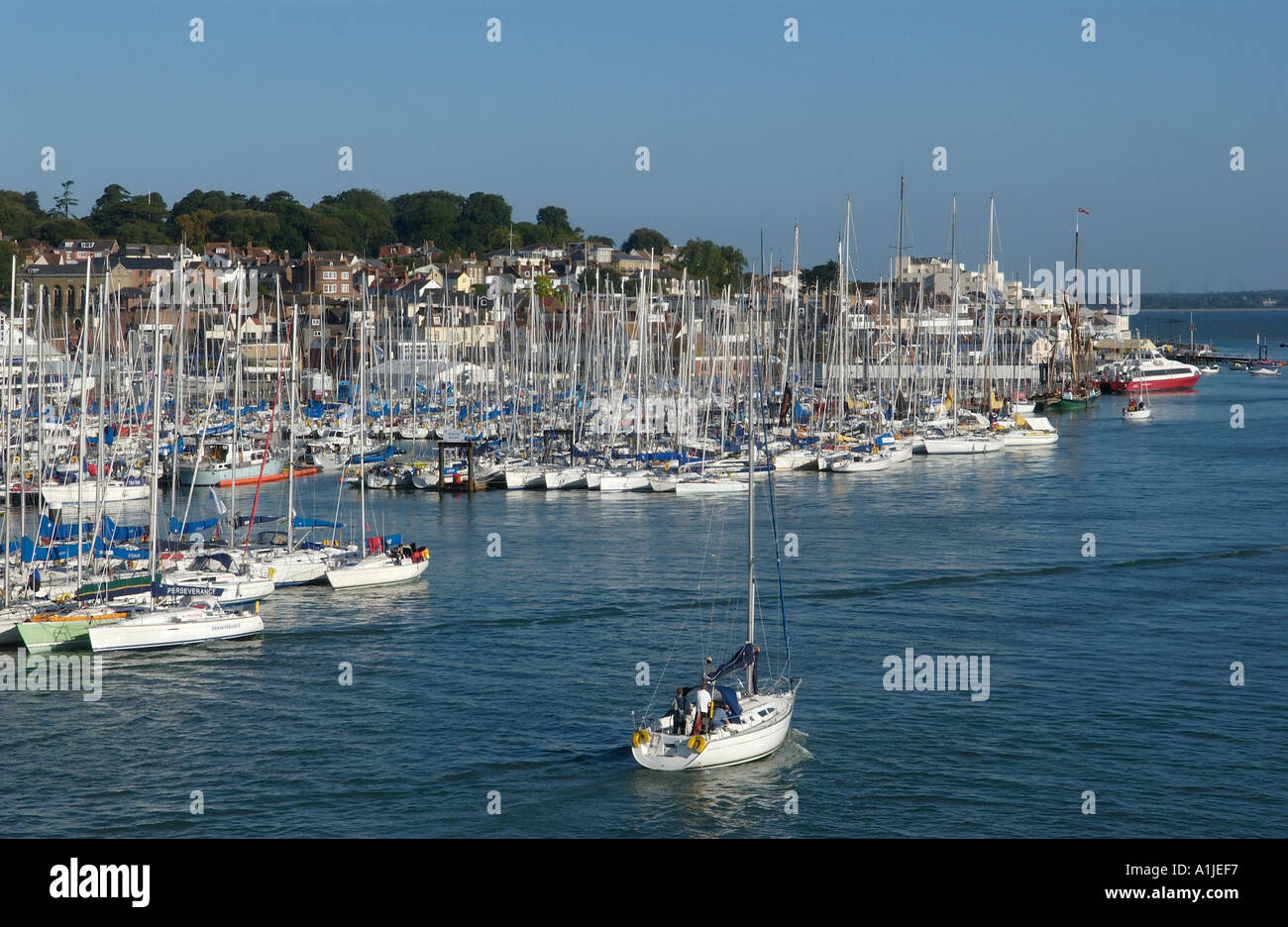 A sailing yacht motors past moorings by Cowes Yacht Haven on the Isle ...