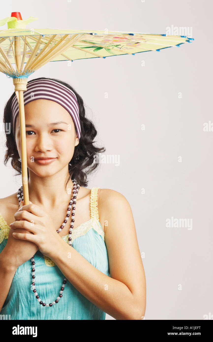 Portrait of a young woman holding a parasol and smiling Stock Photo - Alamy