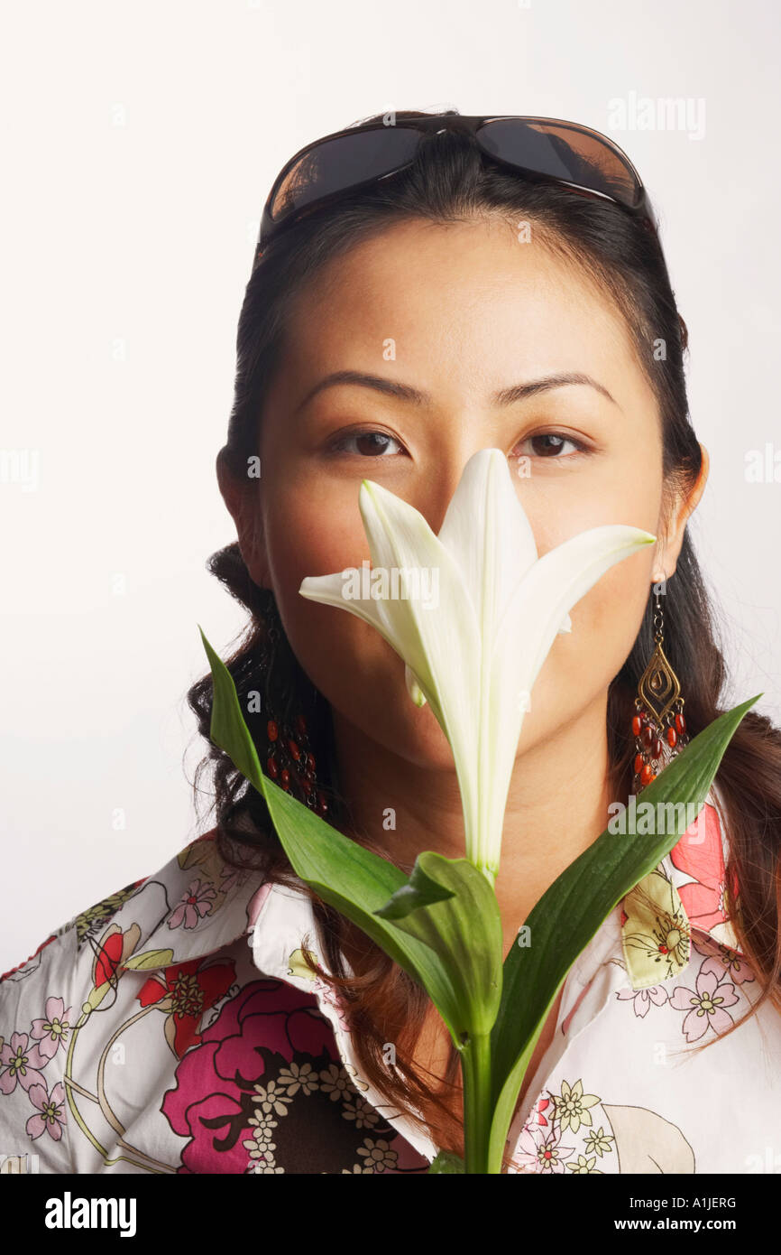 Portrait of a young woman smelling a flower Stock Photo - Alamy