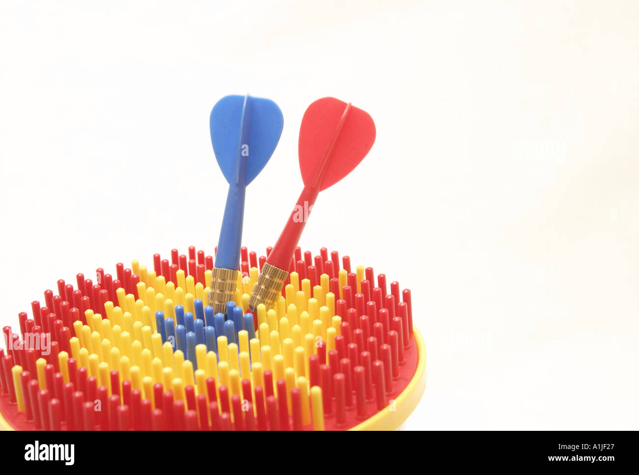 Red and yellow target with red and blue darts in its centre Toy ...