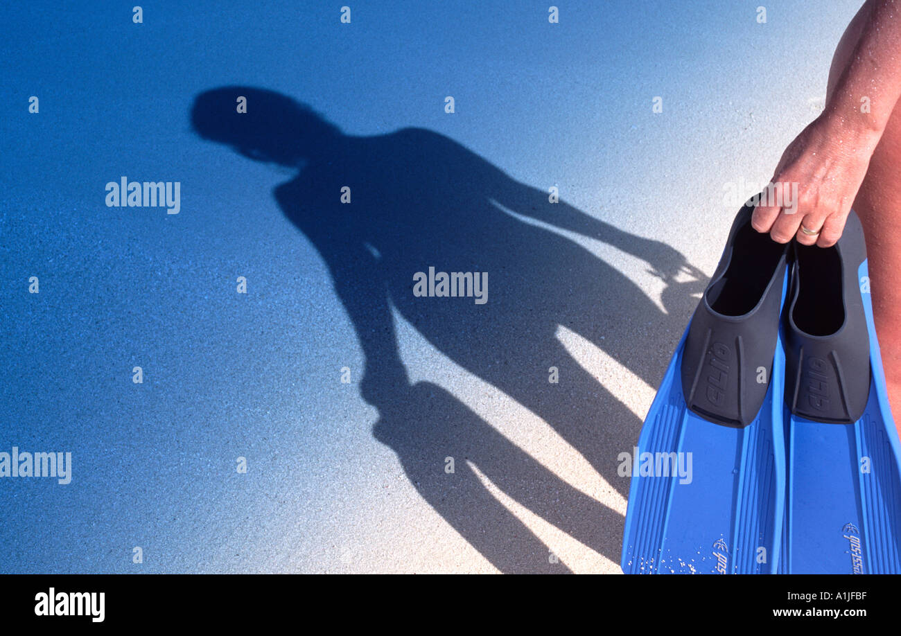 Shadow of woman snorkeller on vacation walking on sandy beach in the ...