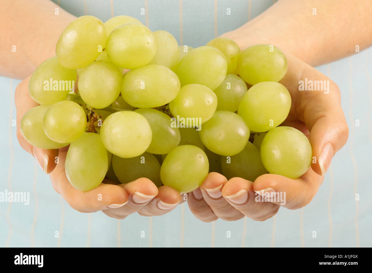 WOMAN WITH HANDFUL OF GREEN GRAPES Stock Photo - Alamy