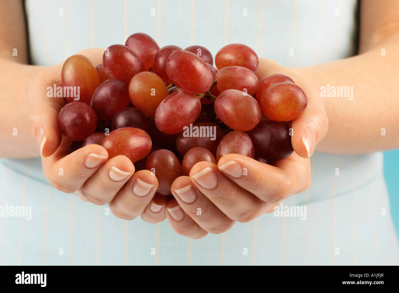 WOMAN WITH HANDFUL OF RED GRAPES Stock Photo - Alamy