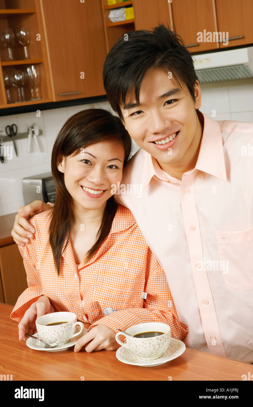 Portrait of a young couple smiling at a kitchen counter Stock Photo - Alamy