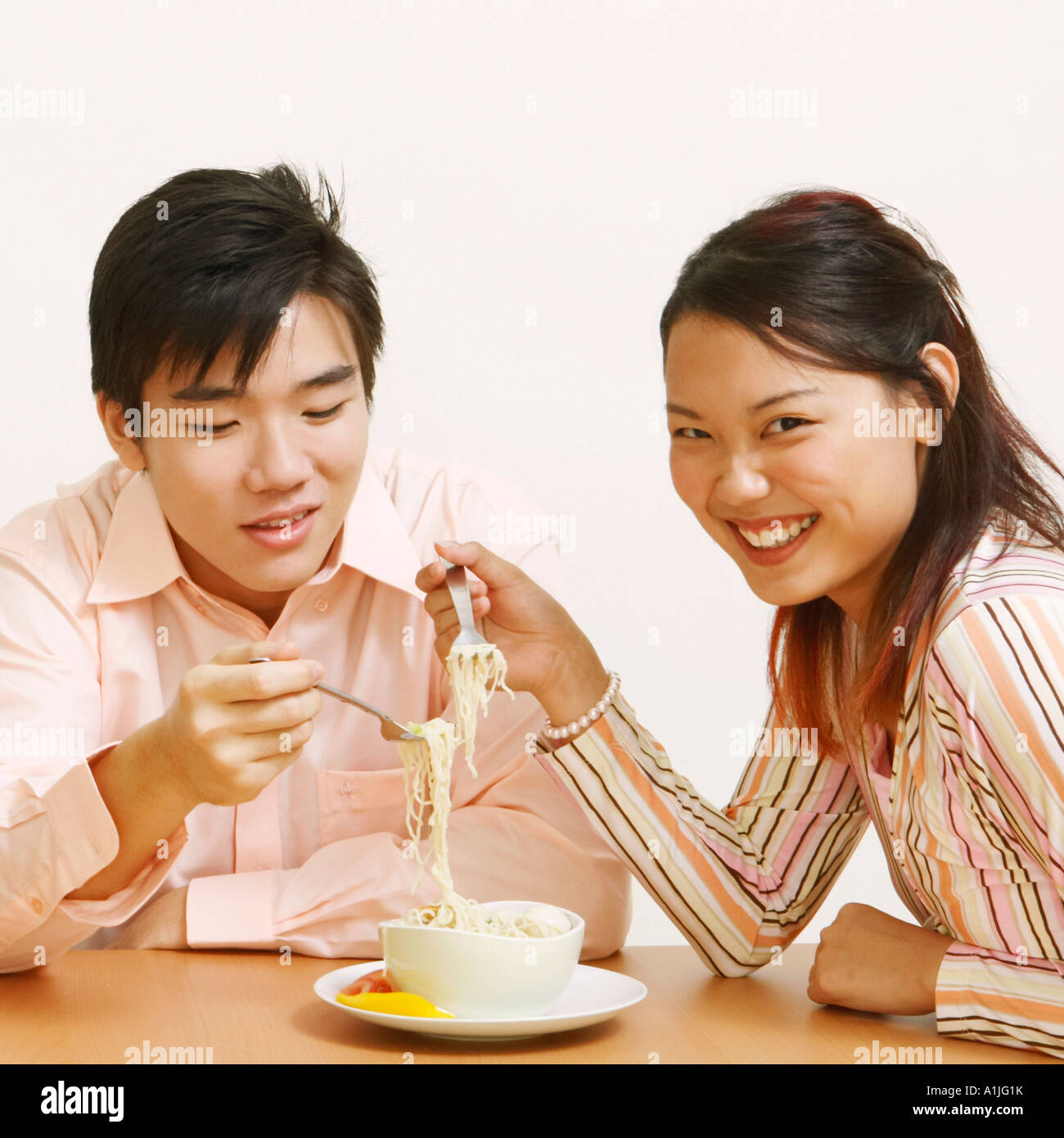 Young couple eating noodles hi-res stock photography and images - Alamy