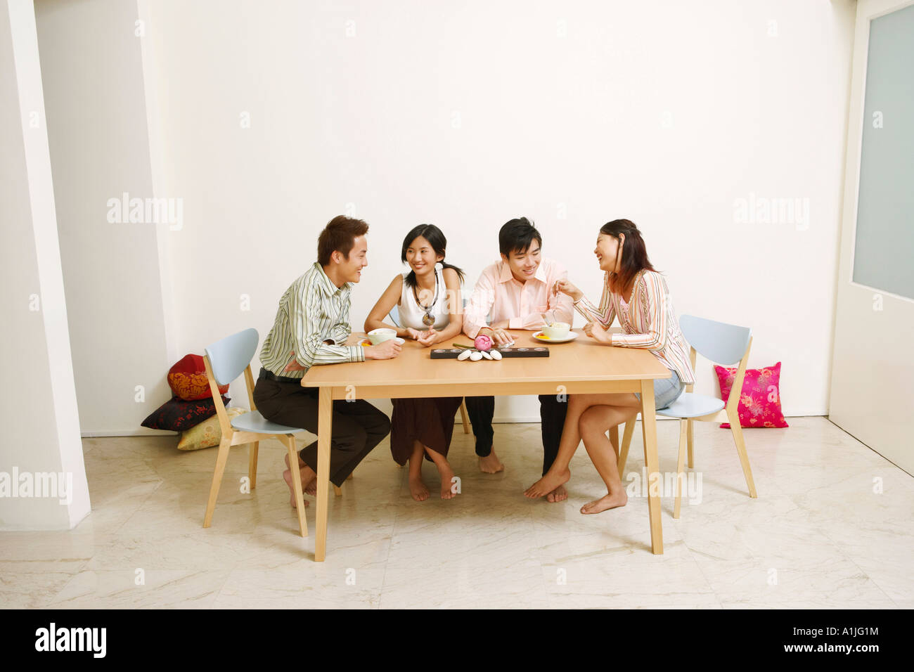 Legs crossed at knee looking away sitting smiling holding hi-res stock ...