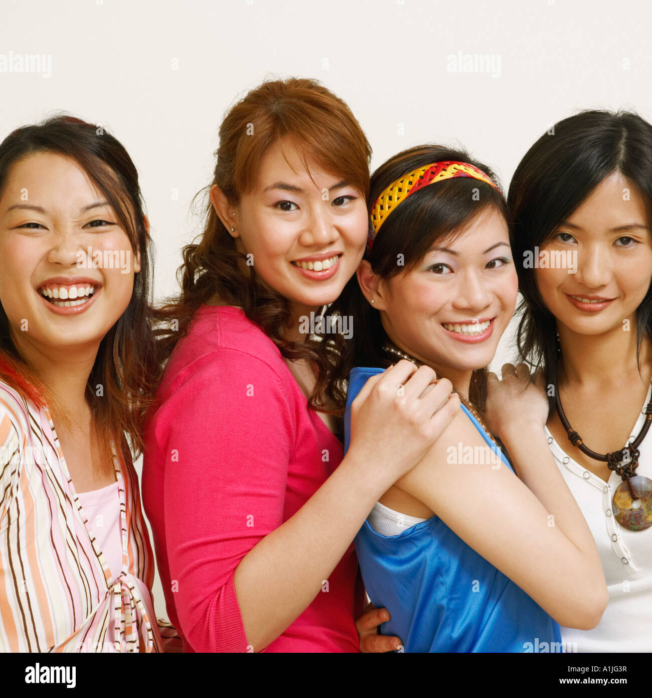 Portrait of four young women hugging each other and posing Stock Photo ...