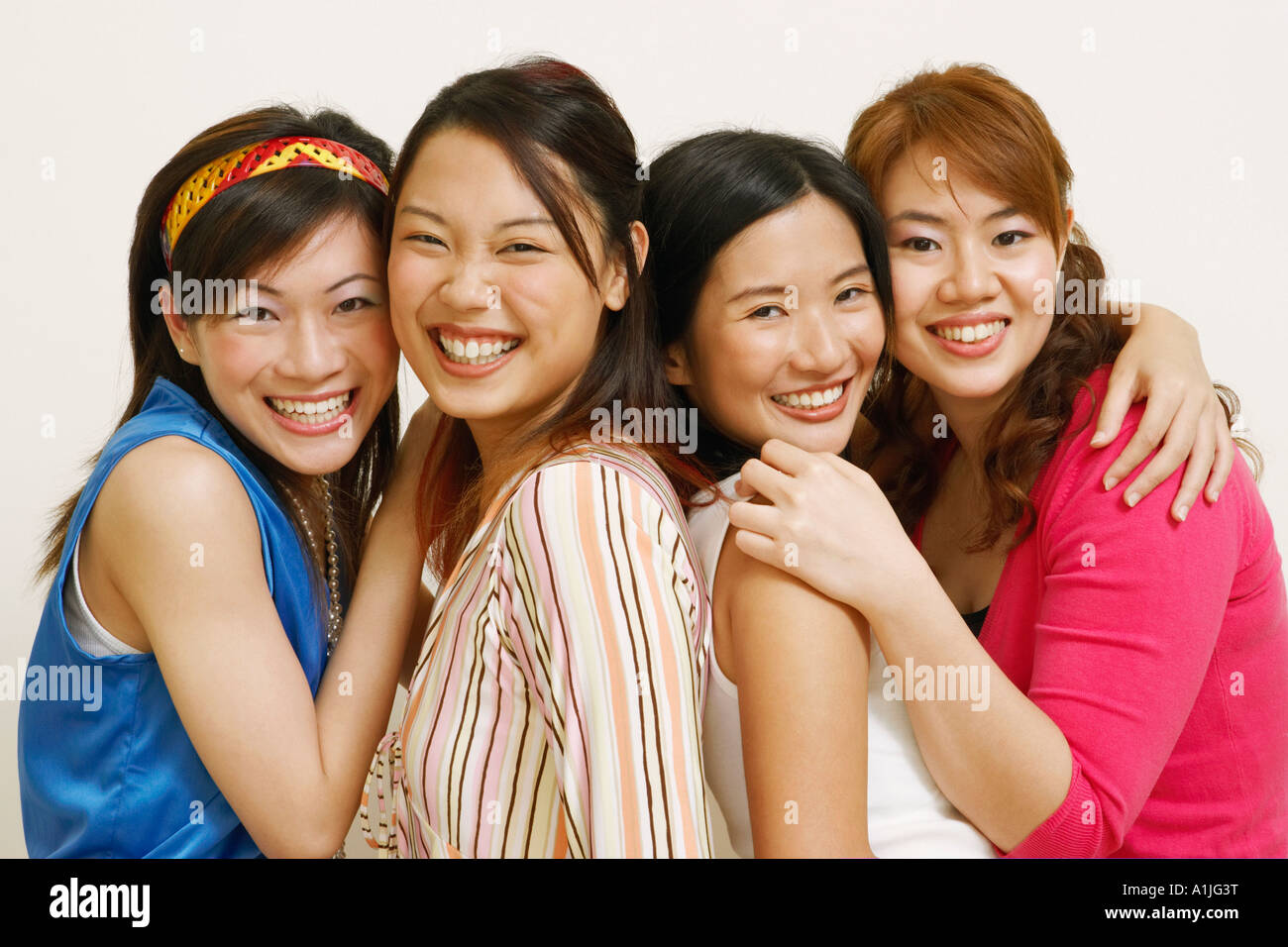 Portrait of four young women hugging each other and posing Stock Photo ...