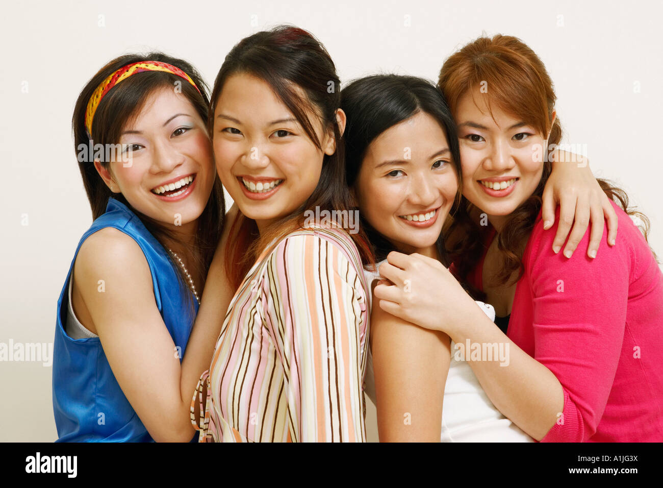 Portrait of four young women hugging each other and posing Stock Photo ...