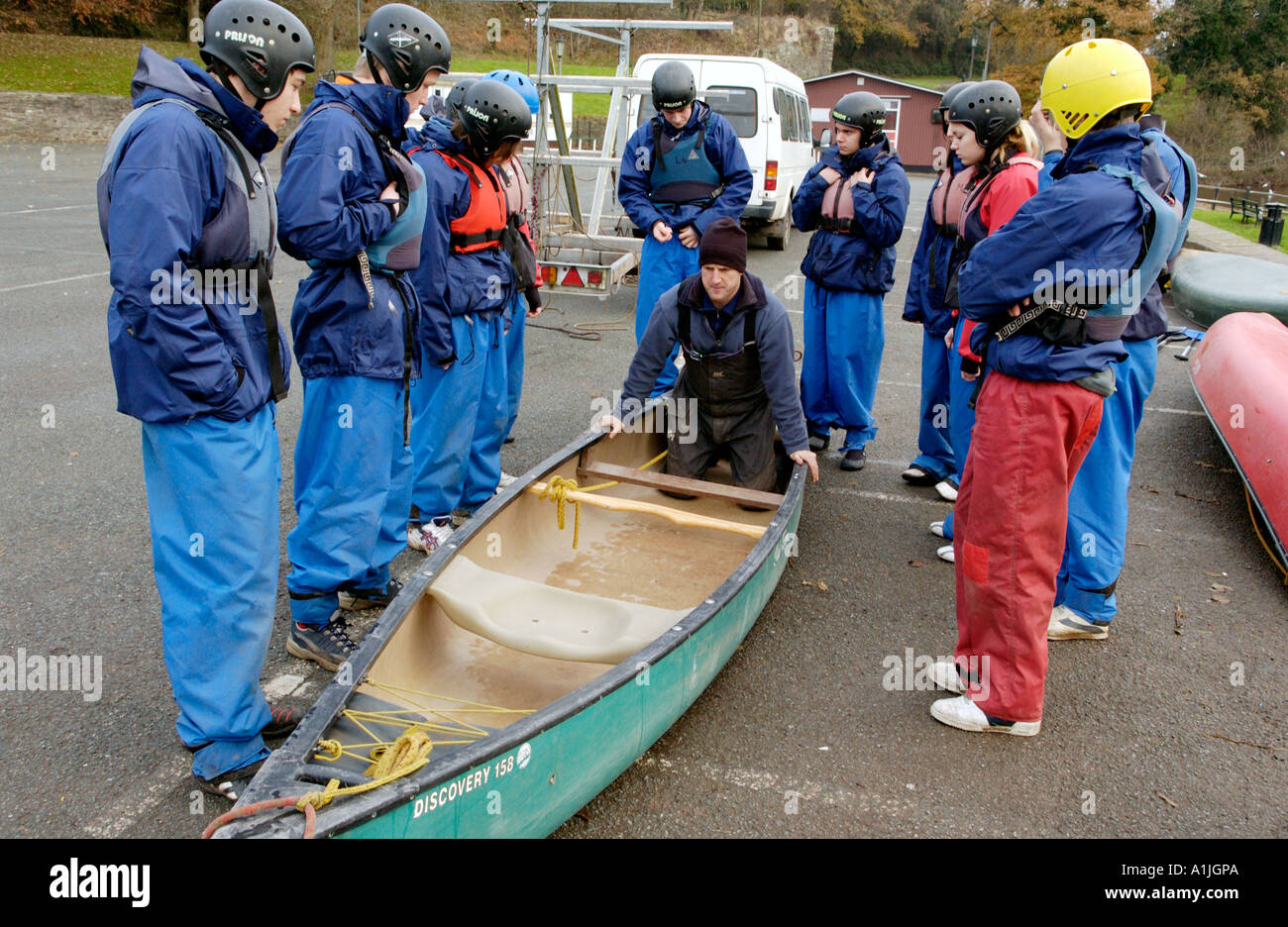 Instructor demonstrating open canoe technique to students on the banks ...