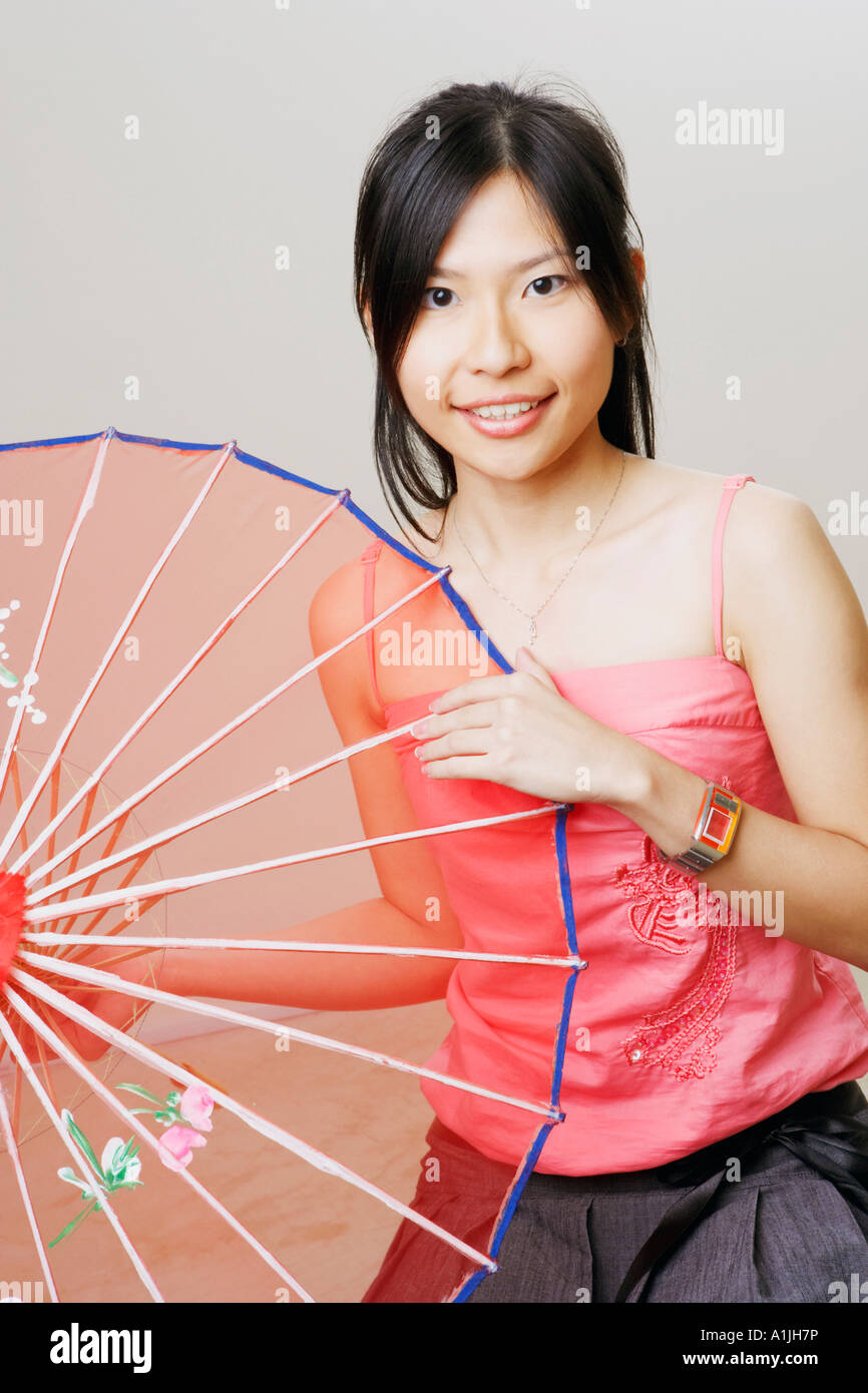 Portrait of a young woman holding a parasol and posing Stock Photo - Alamy