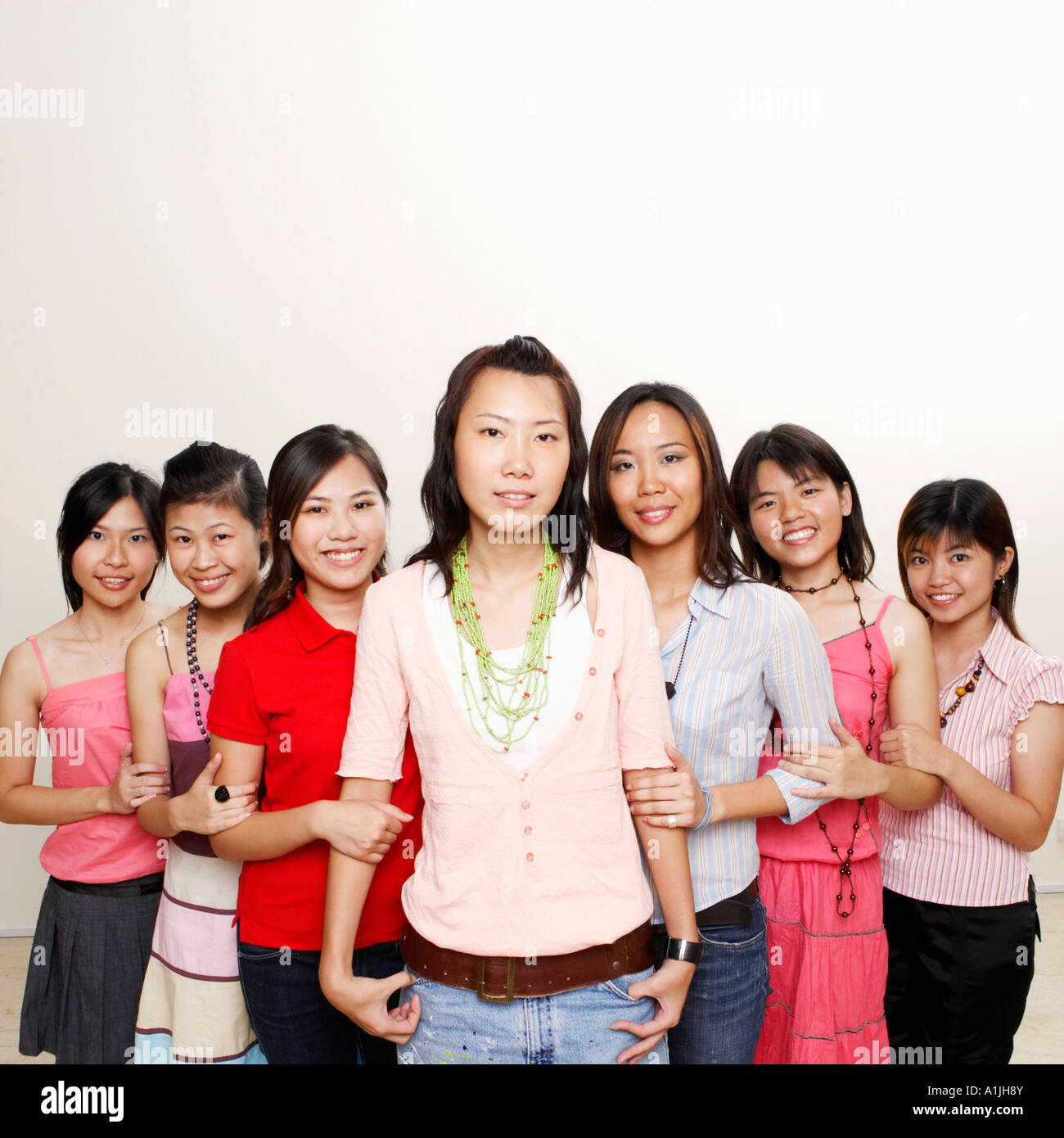 Portrait of a group of young women holding hands of each other and ...
