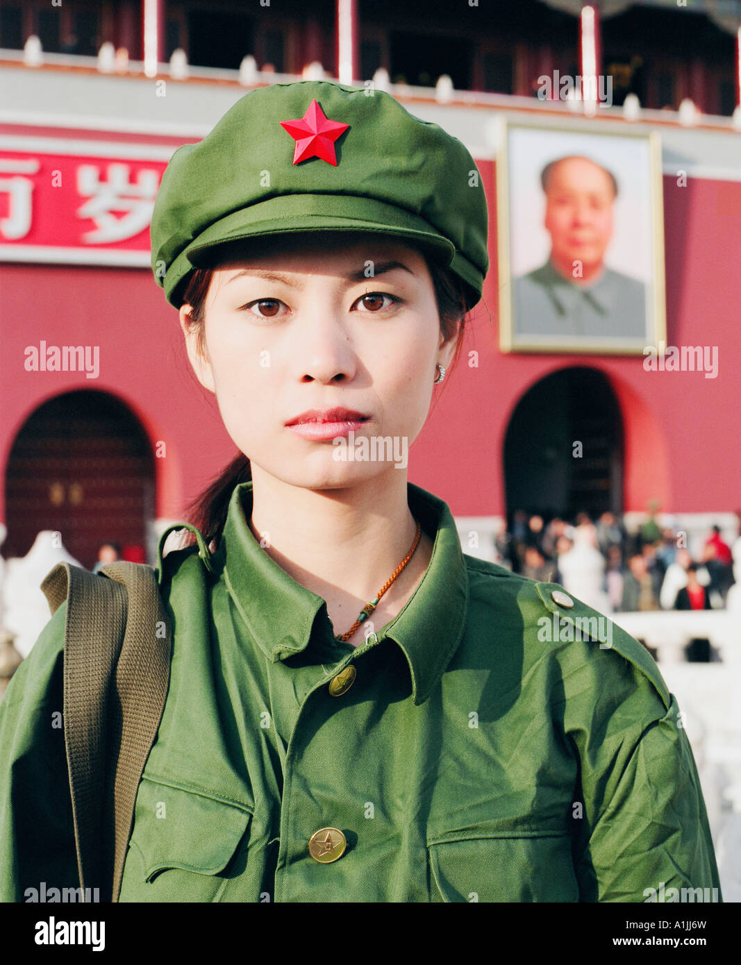Portrait of a young woman in army uniform standing in front of a palace ...